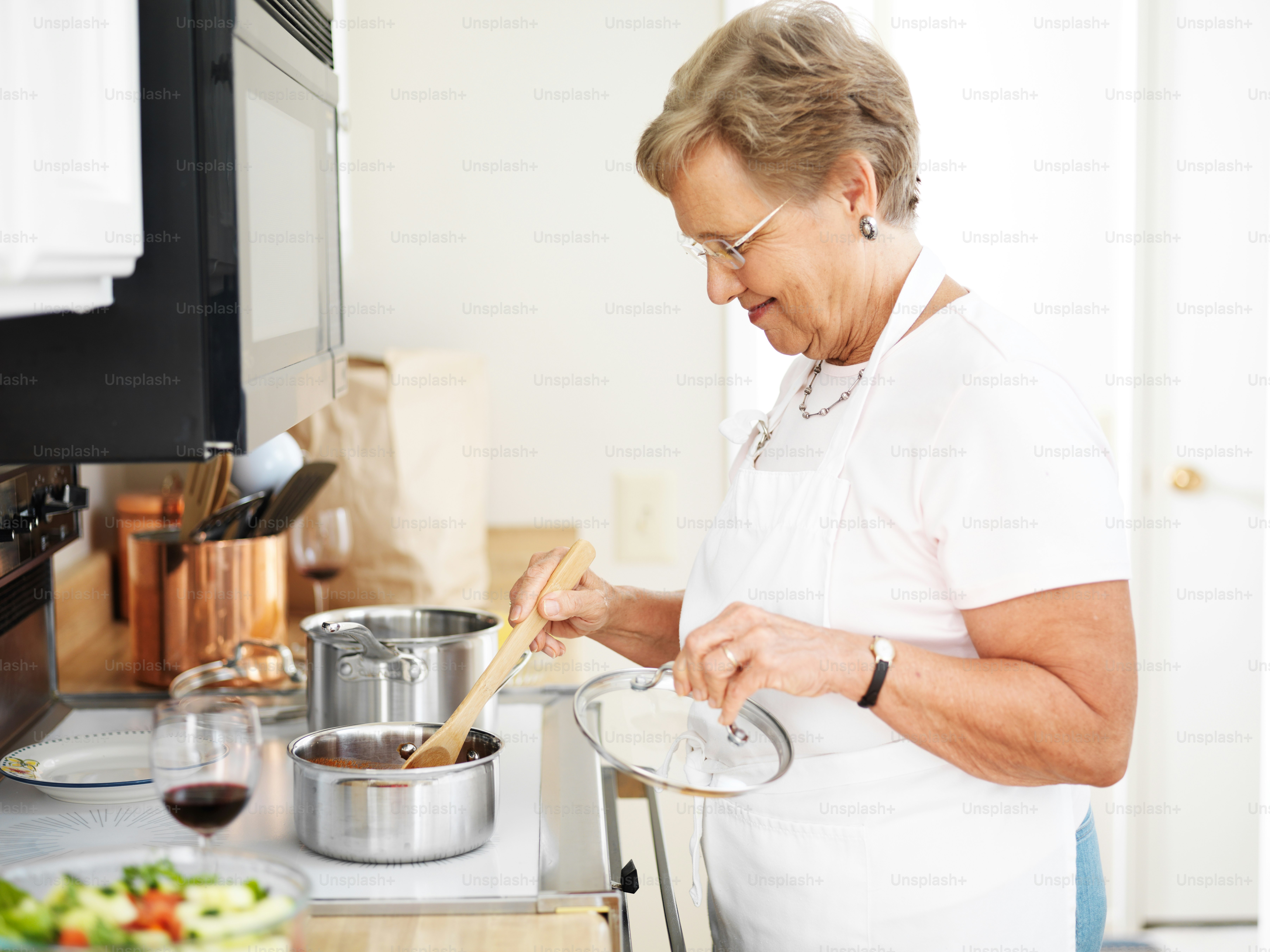 Grandmother cooking in the kitchen with wooden spoon. photo – Savory ...