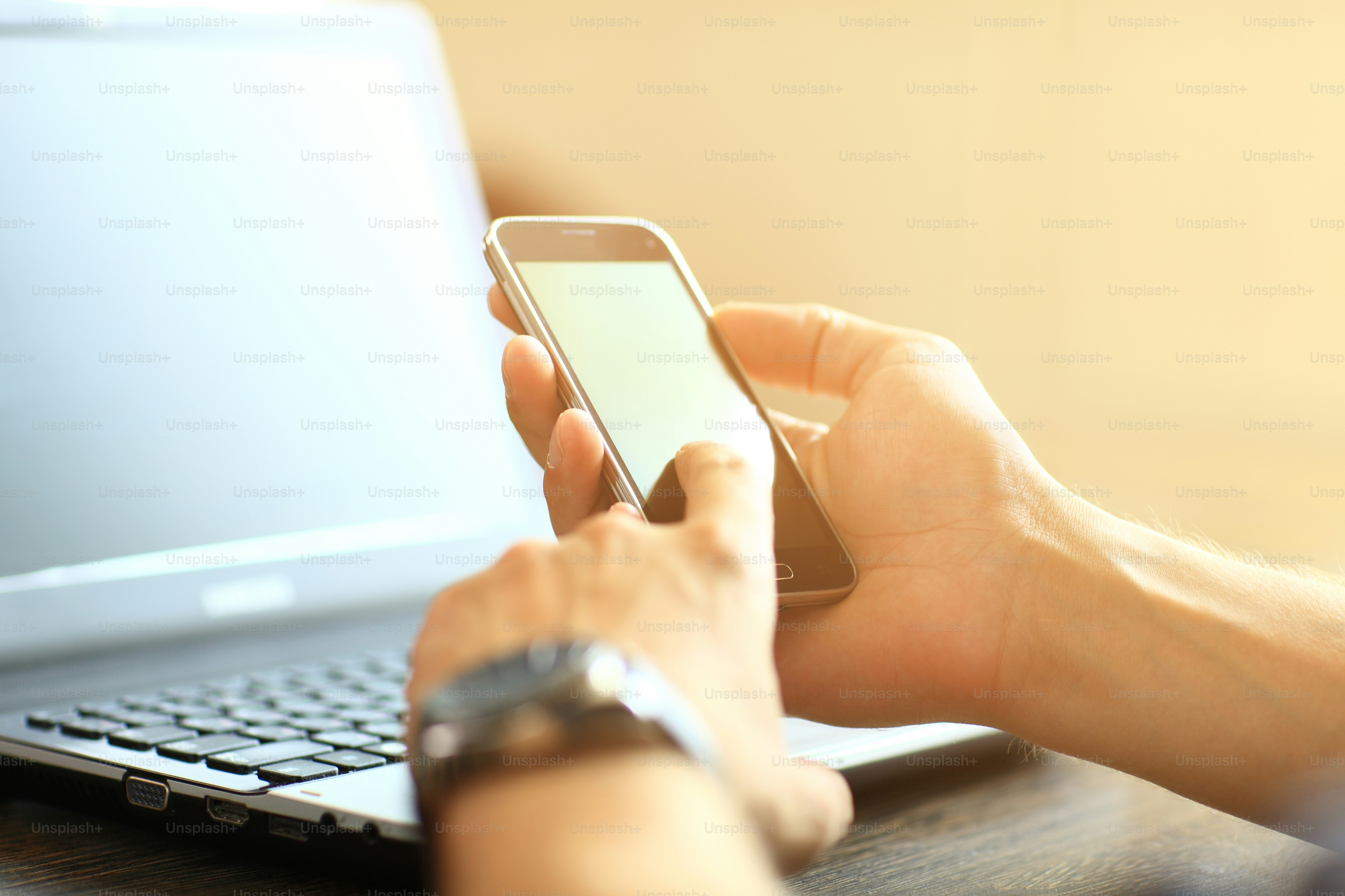 Silhouette of cropped shot of a young man working from home using smart ...