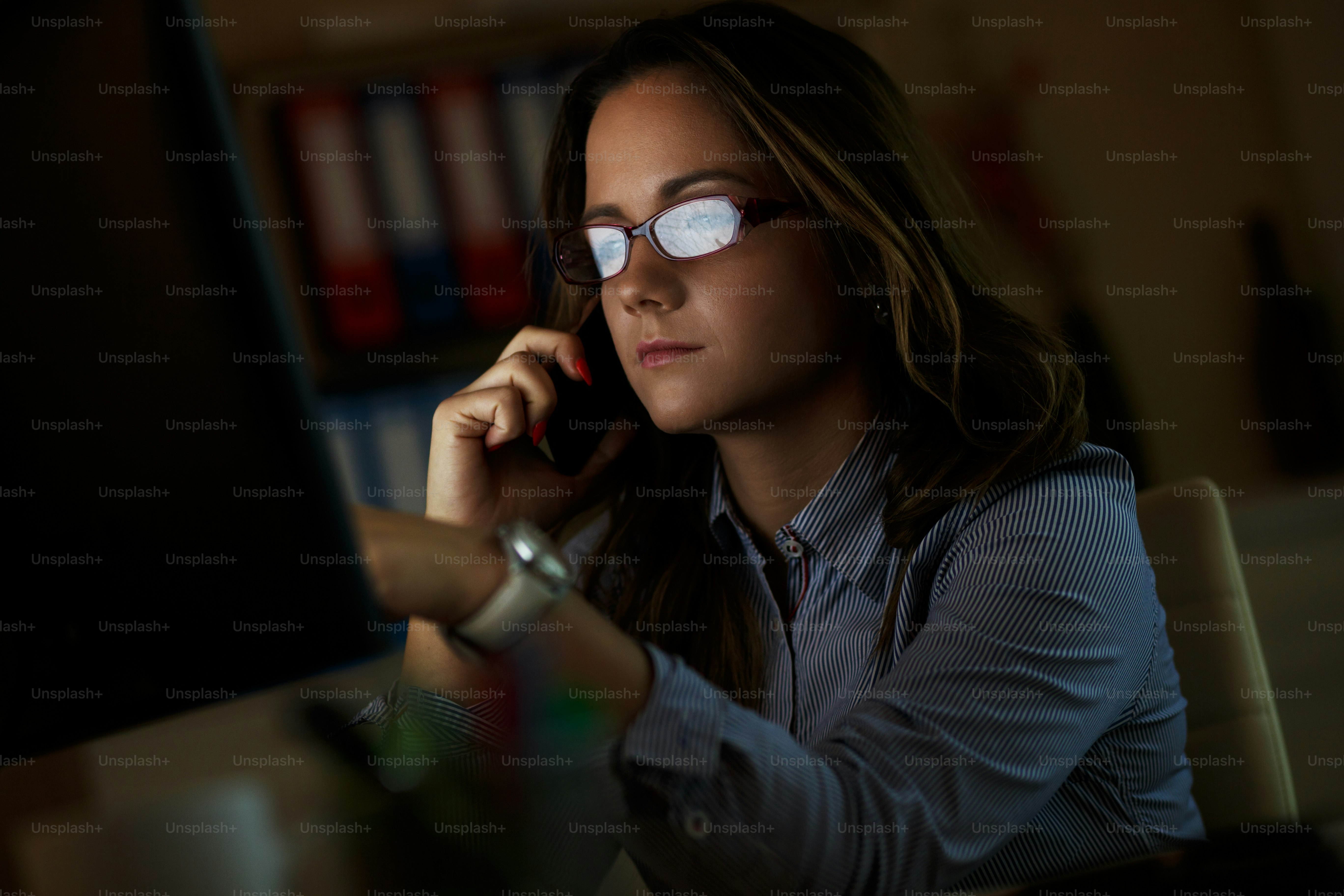 Young business woman working late in office.She works late into the ...