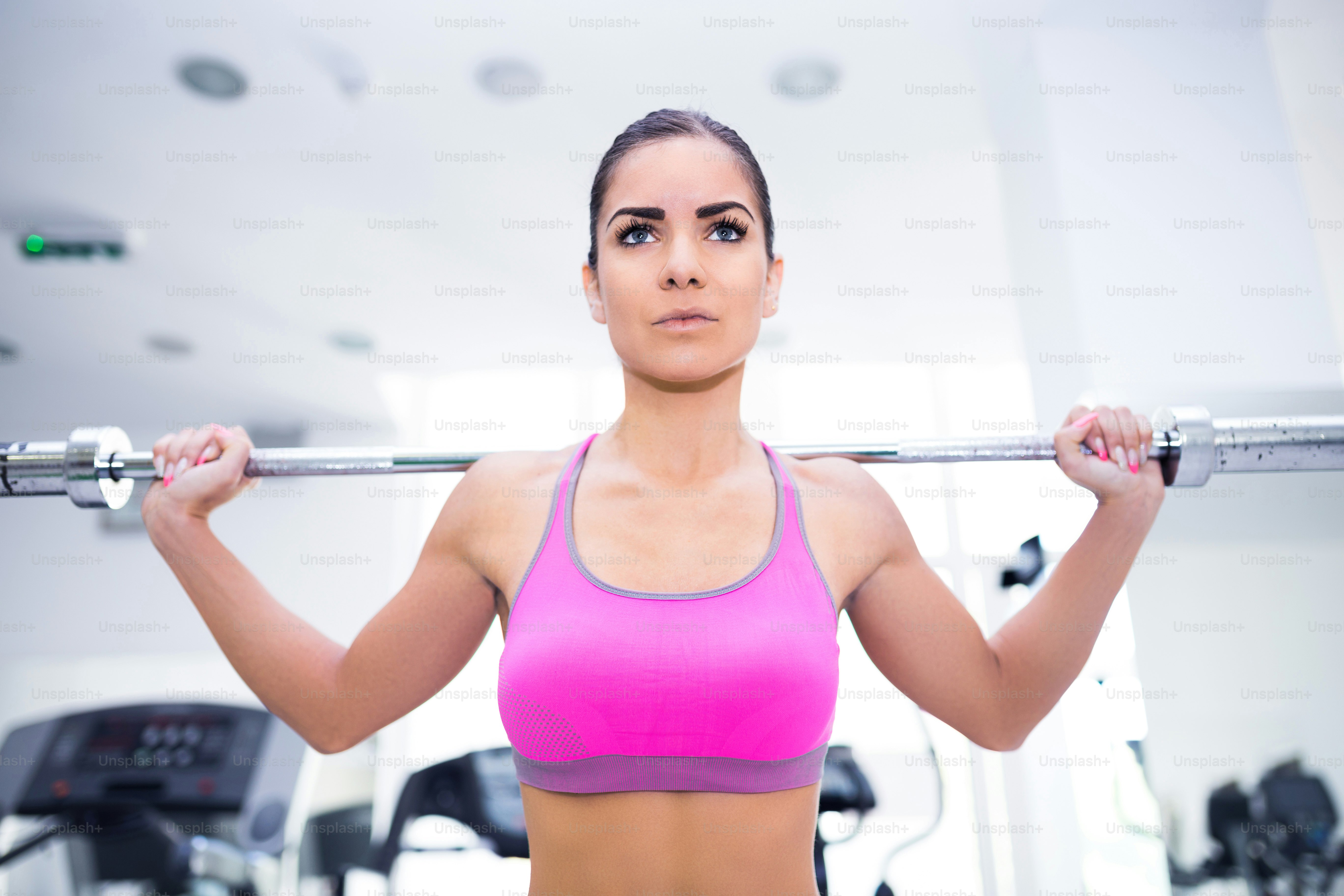 Beautiful and attractive young woman doing exercises at fitness gym ...