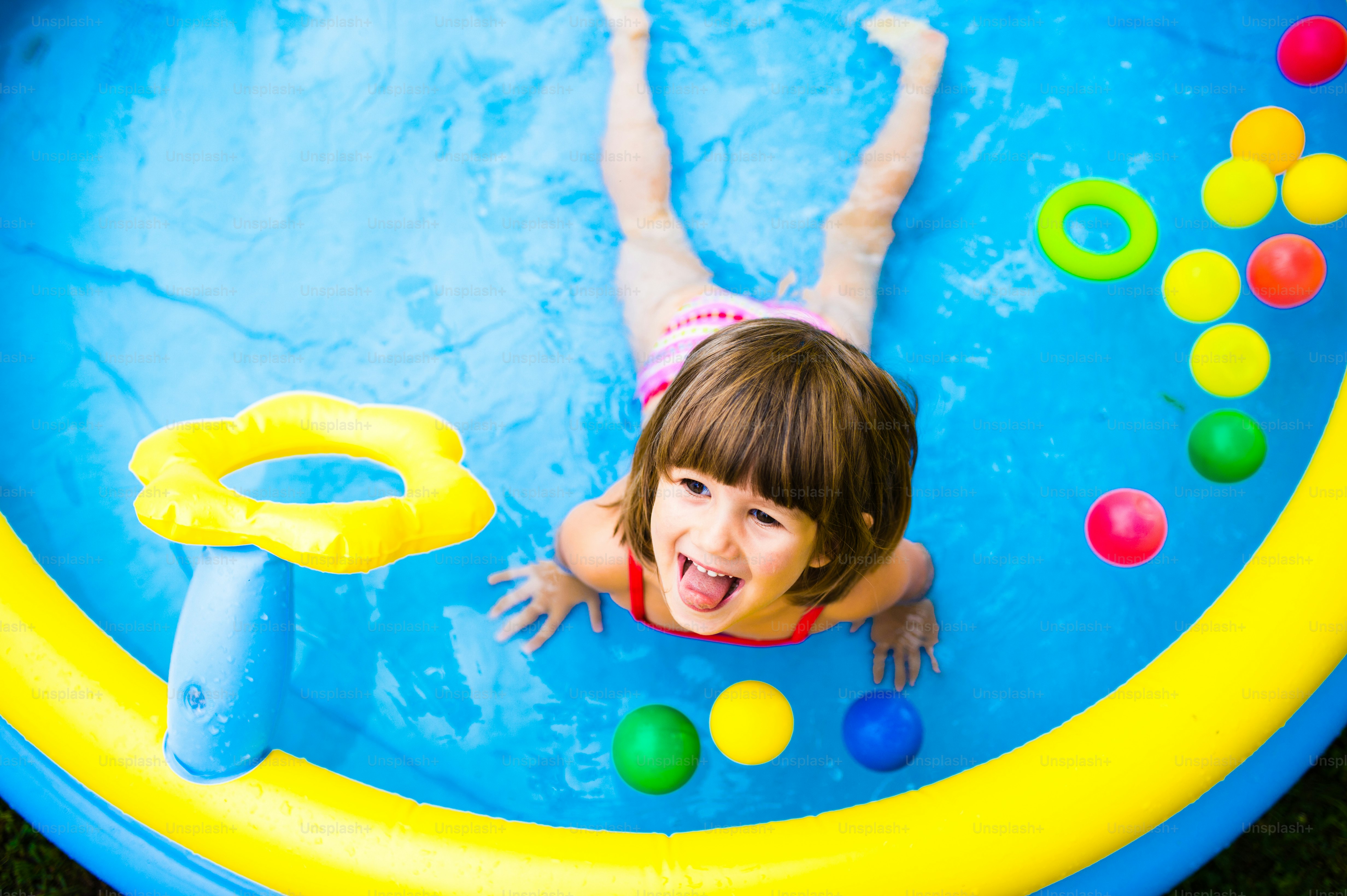 Cute little girl having fun in blue garden swimming pool. Sunny summer ...