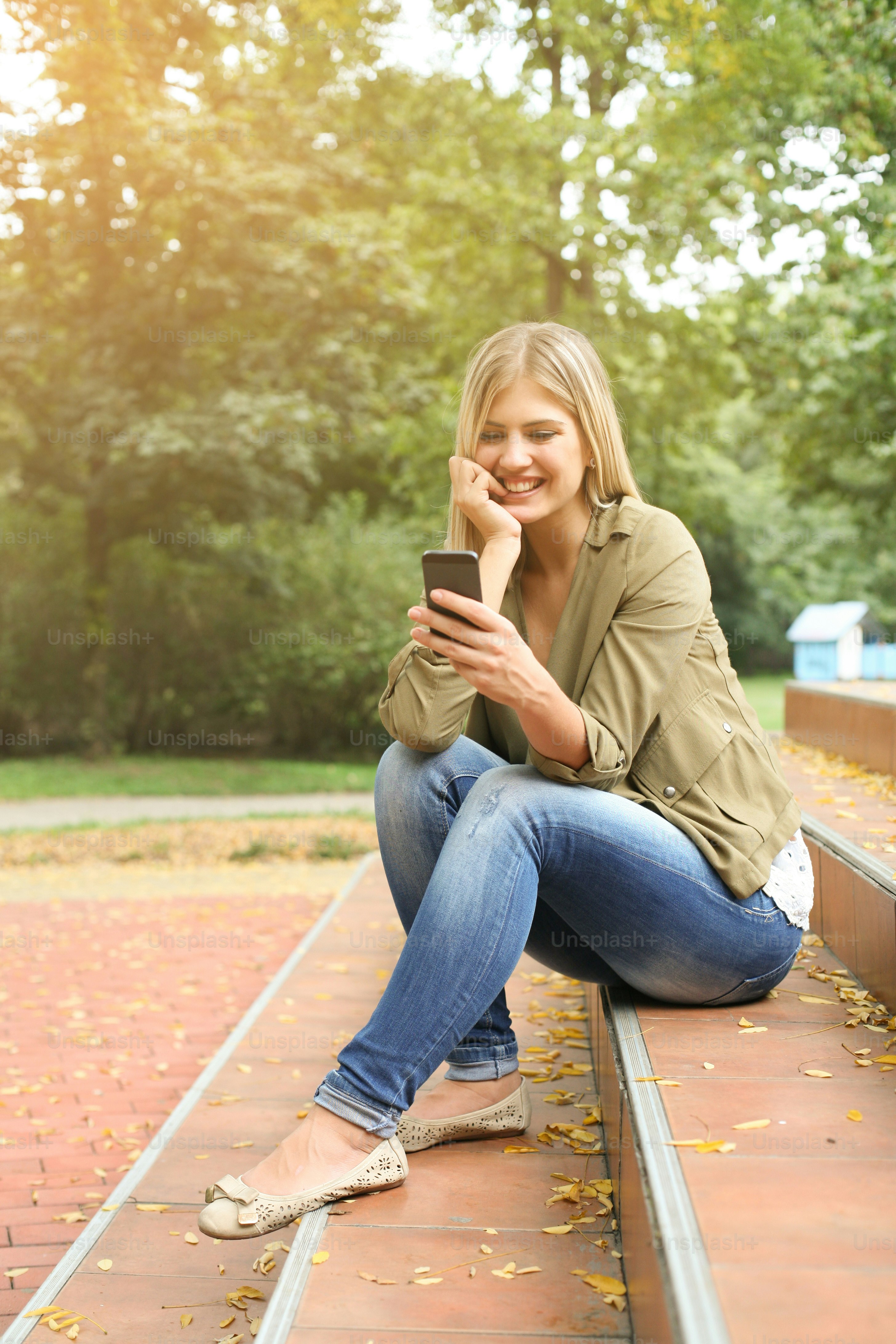 Beautiful woman using smart phone outdoors. photo – Springtime Image on ...