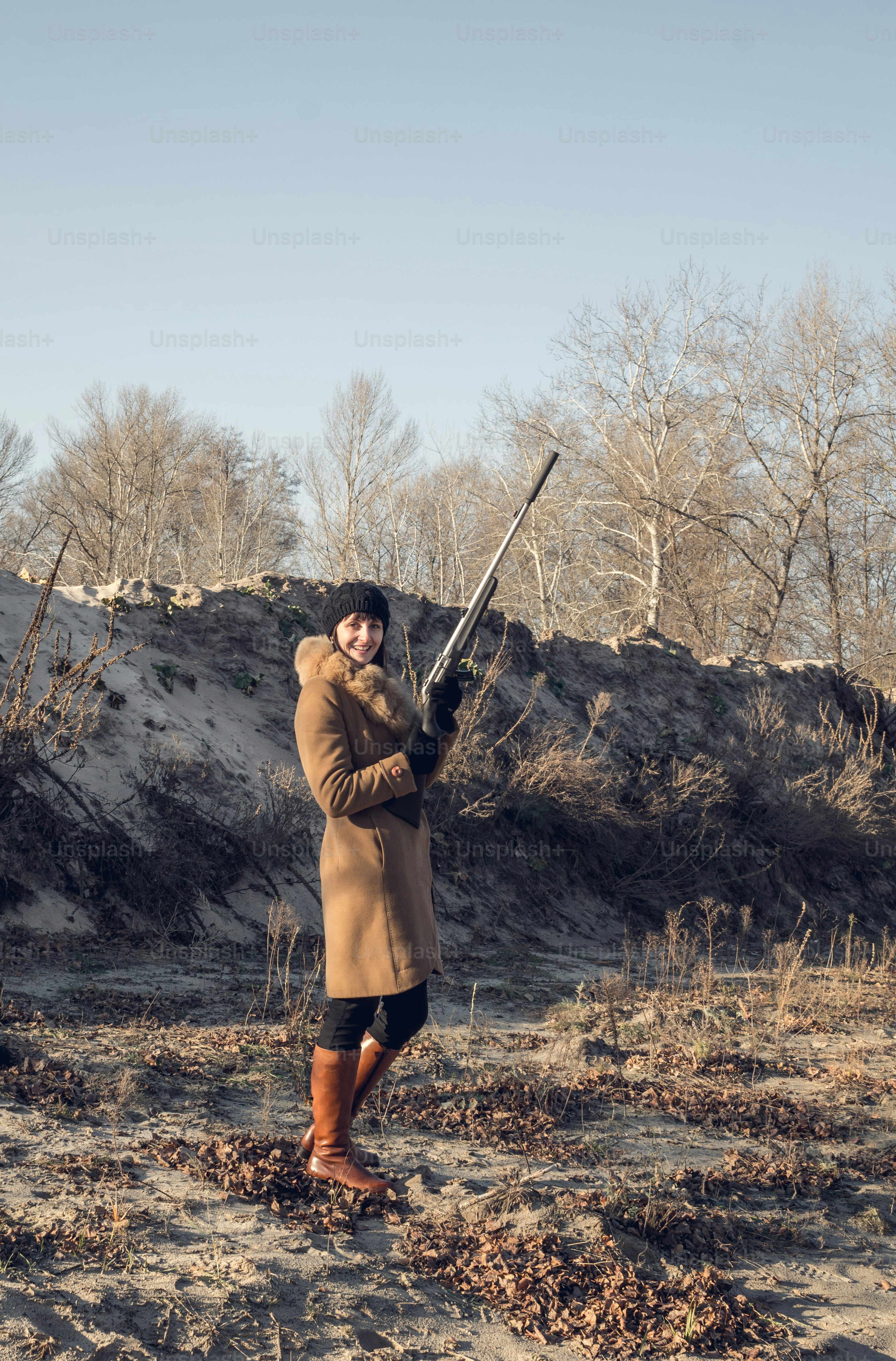 English hunting. Young beautiful woman in a hunting coat with a gun in ...