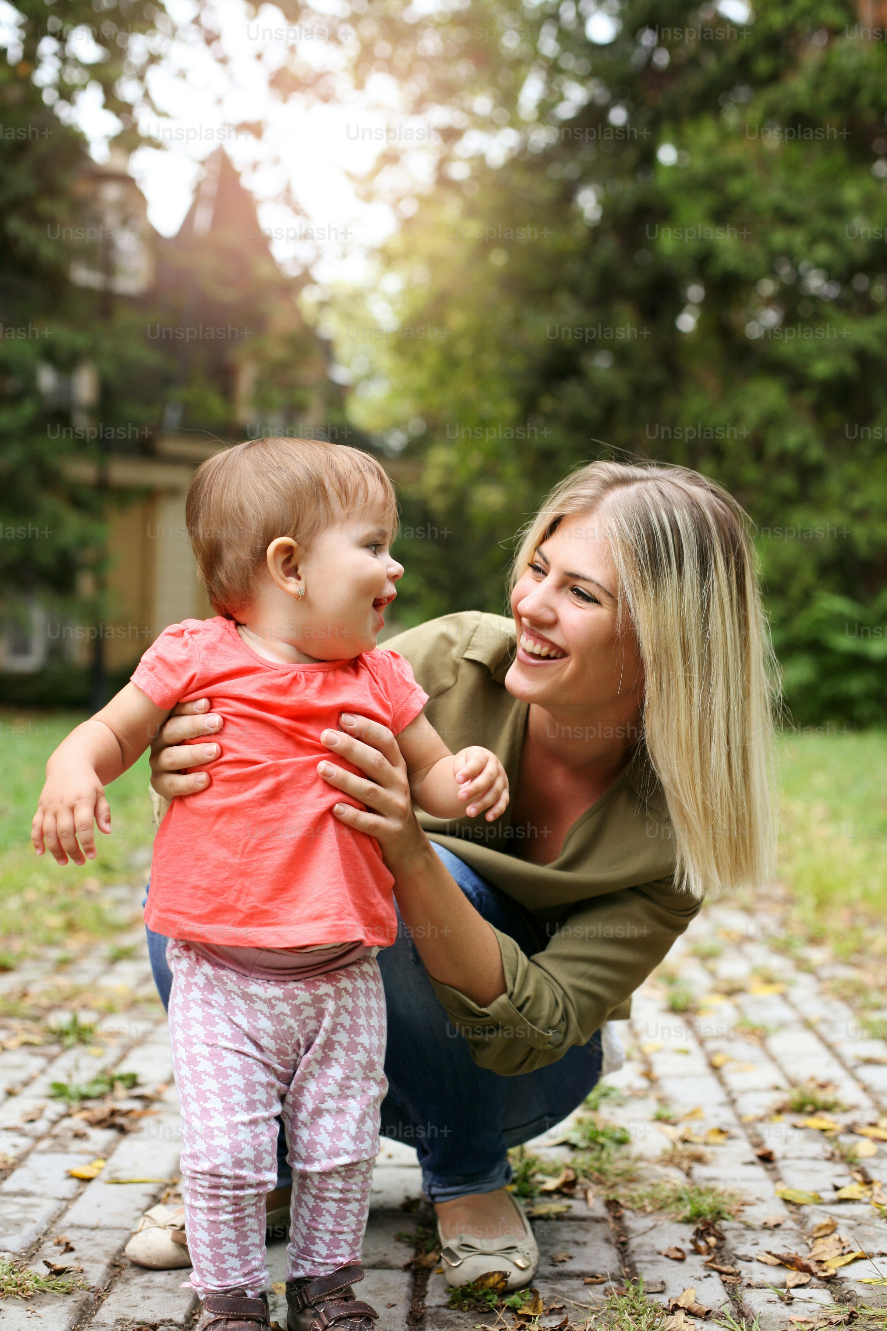 Foto zum Thema Junge Mutter bringt ihrer Tochter ihre ersten Schritte ...