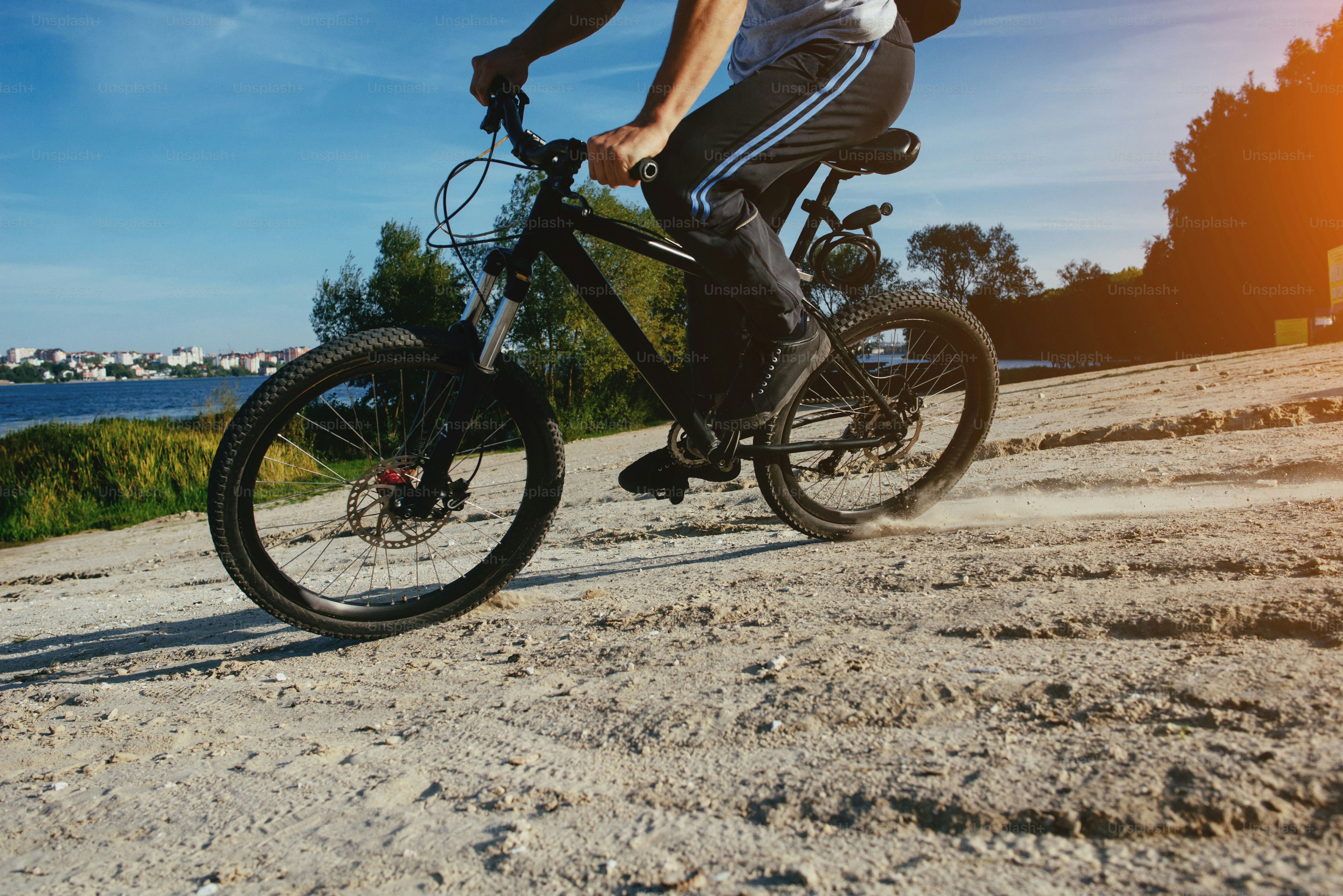 Attractive Biker riding along beach at sunset photo – Muscular build ...
