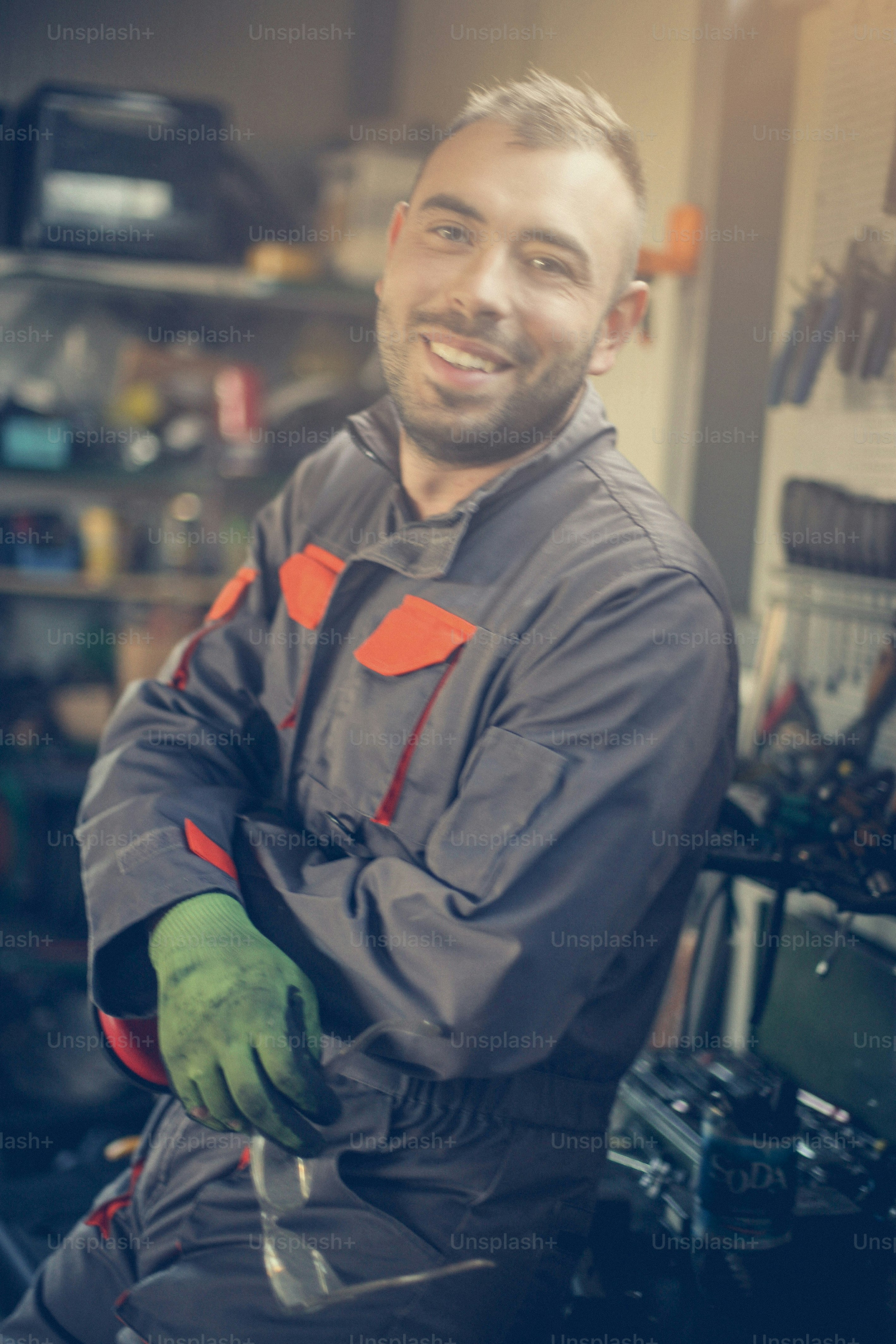Mechanic relax in his workshop. Looking at the camera. photo – Standing ...
