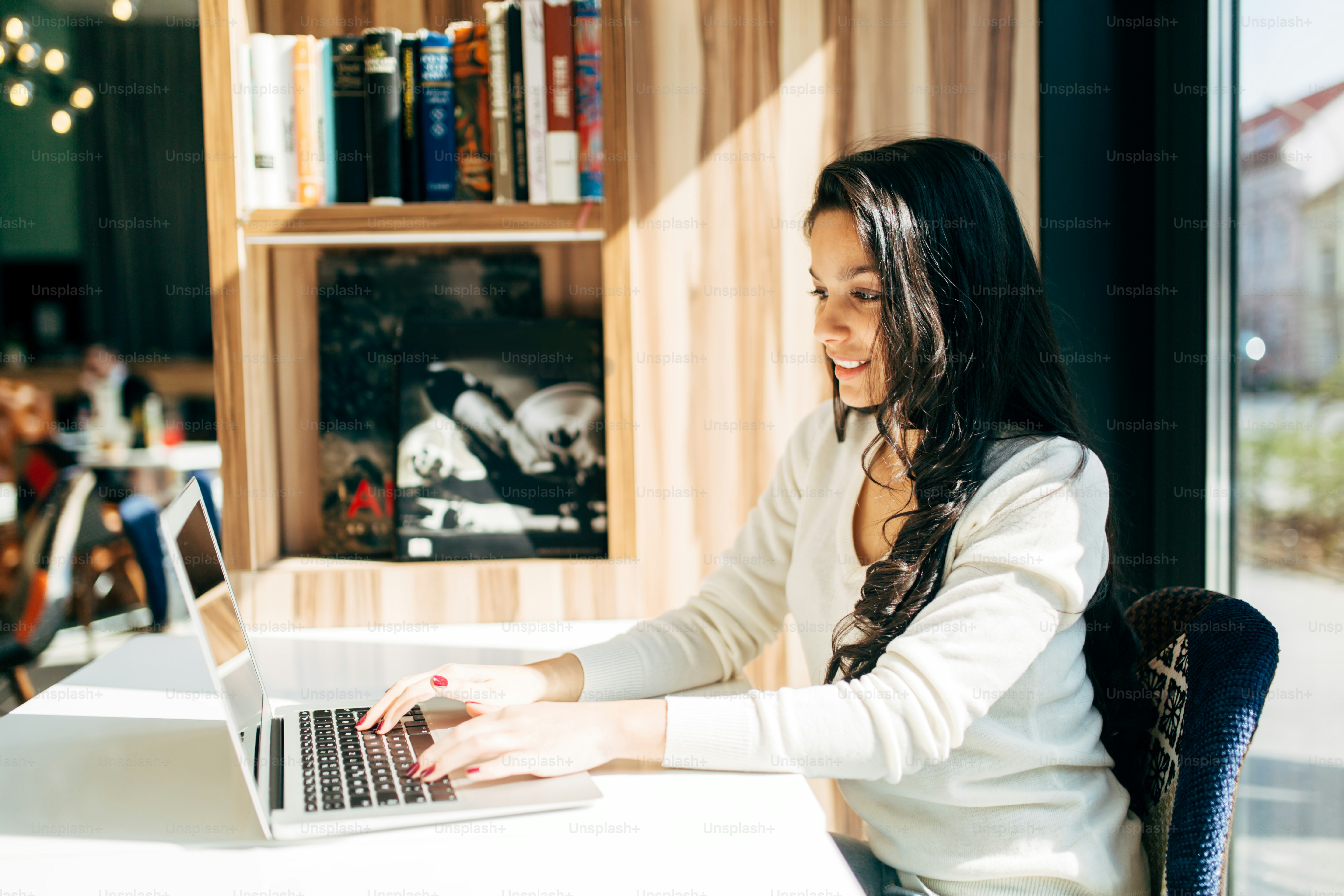 Hermosa morena usando computadora portátil en café foto – Imagen de ...