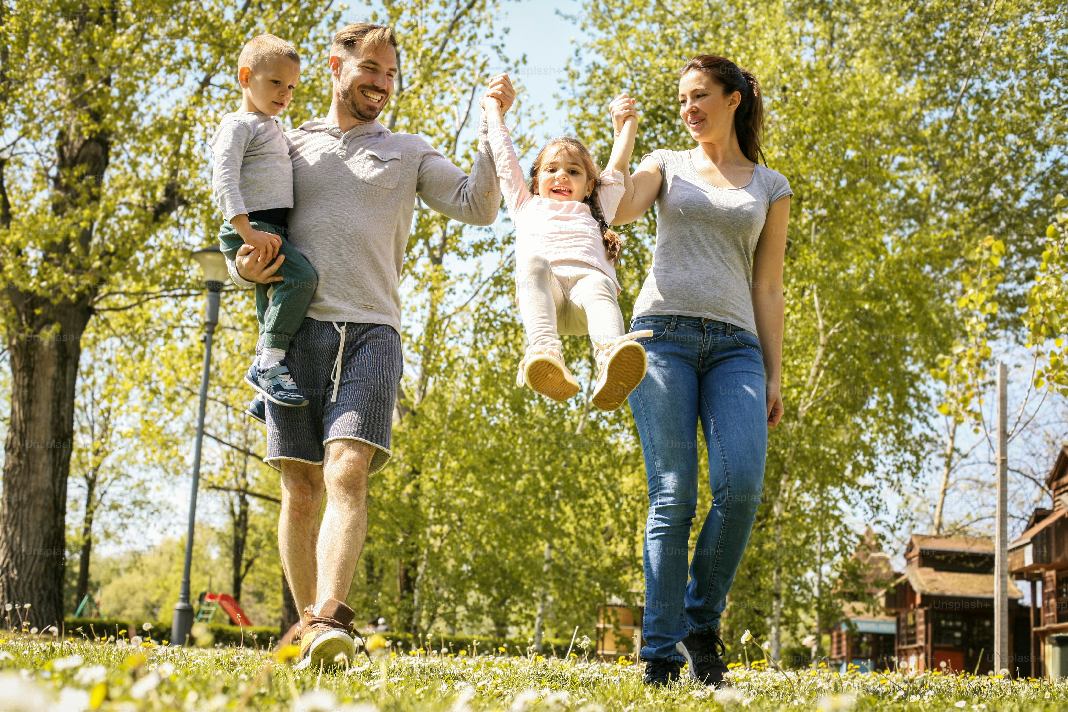 Happy parents playing with their children in the meadow. photo ...