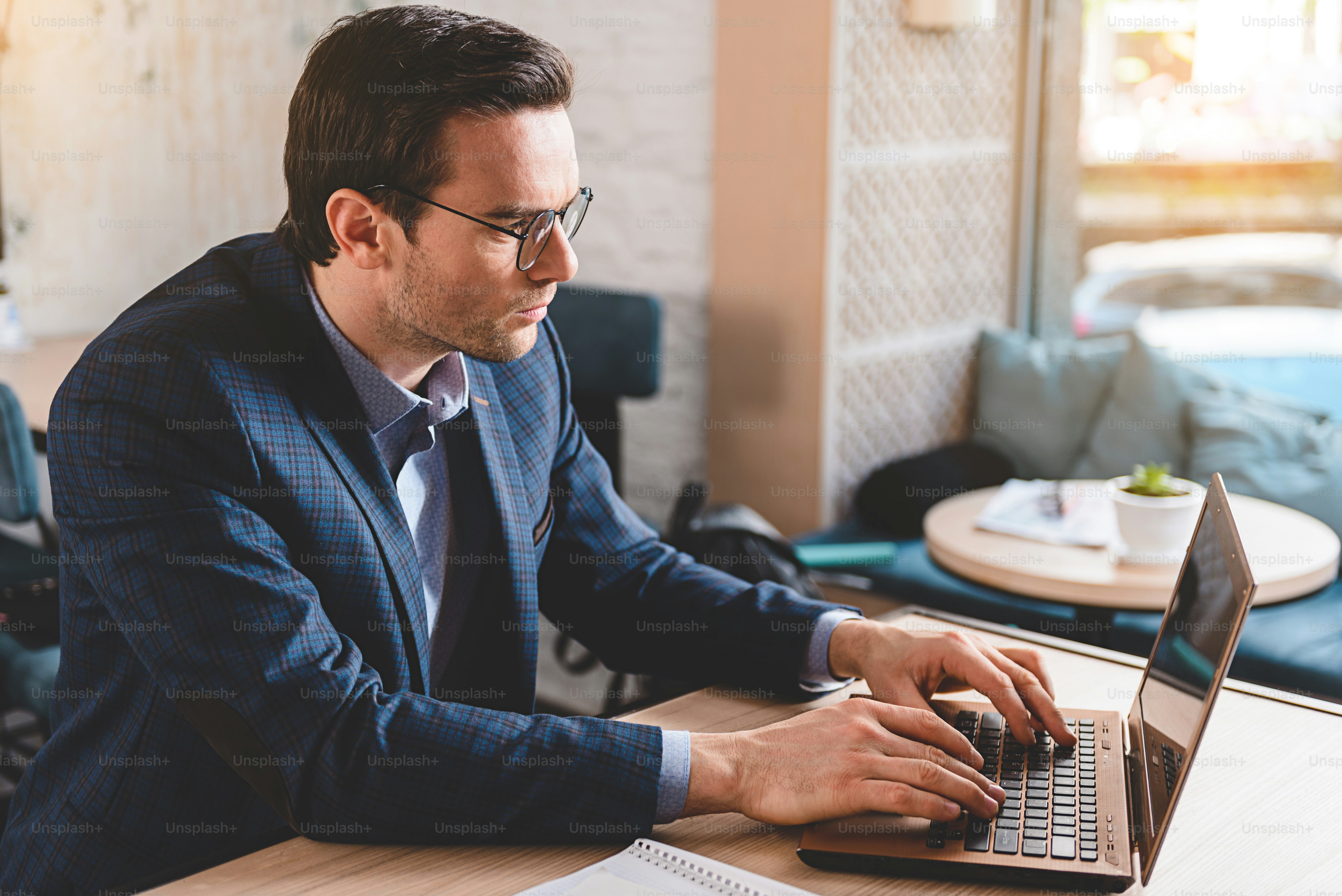 Side view serene stubbled smart operator writing for laptop while ...