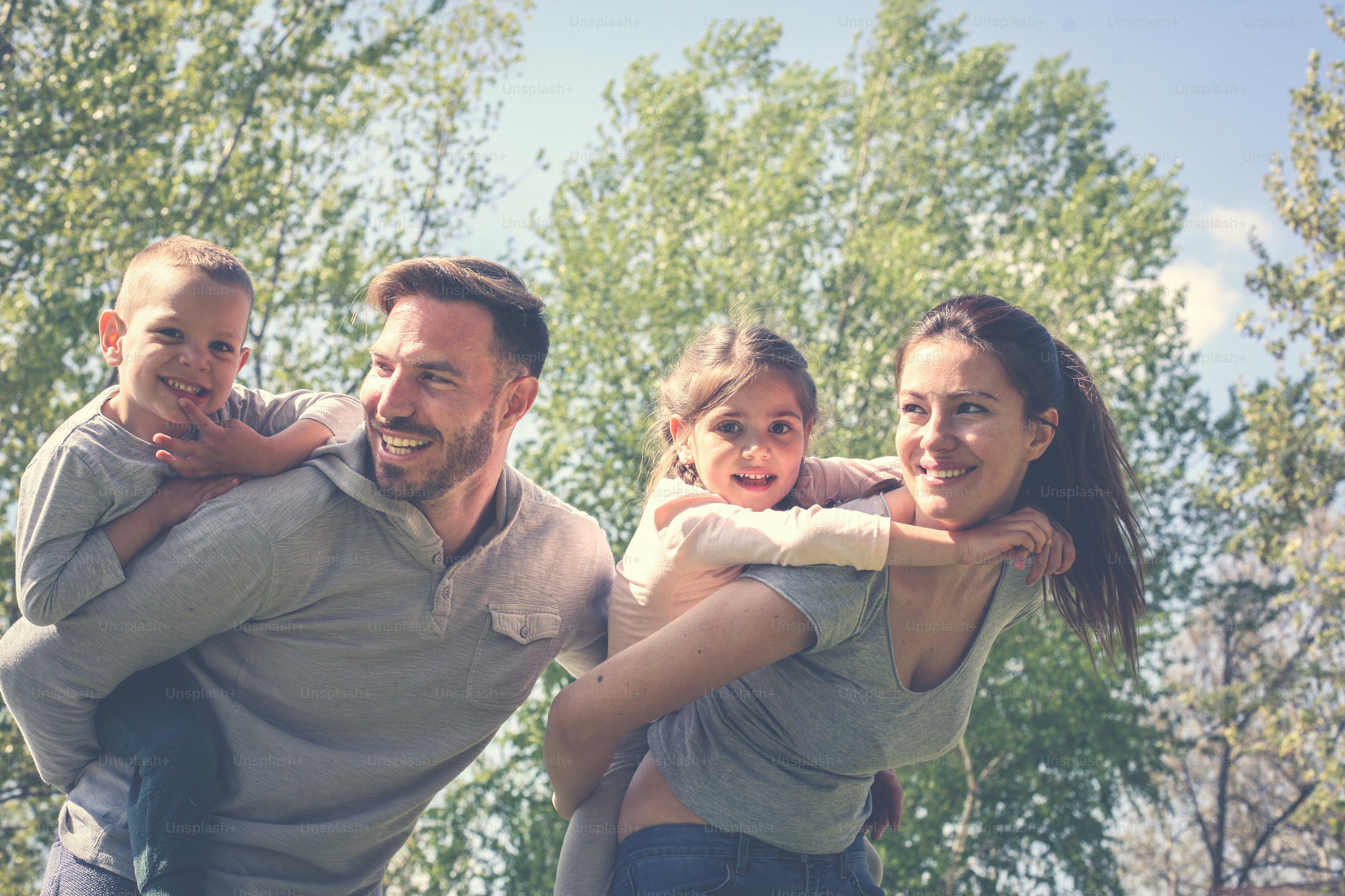Foto zum Thema Eltern, die mit ihren Kindern im Park spielen. Blick in ...