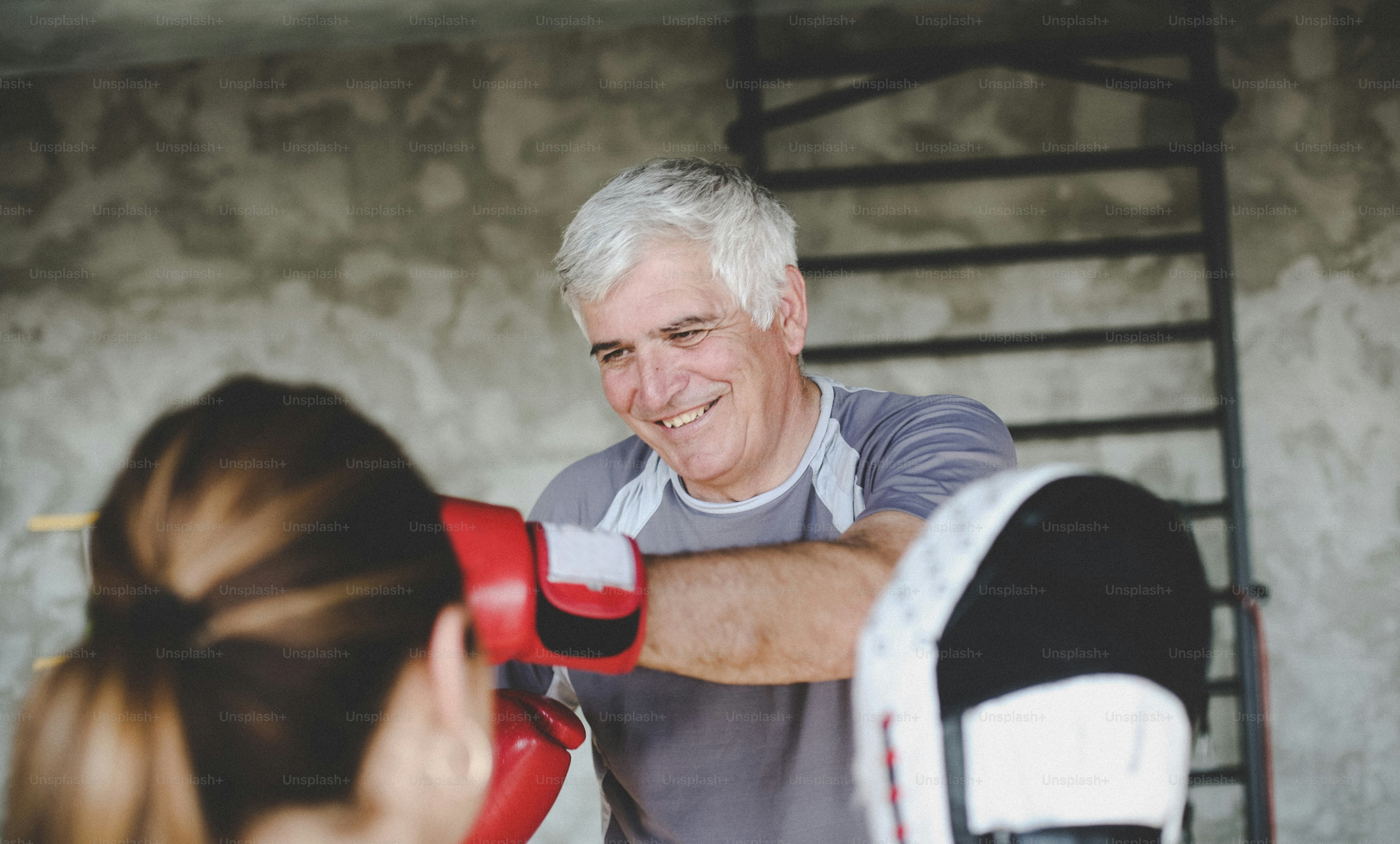 Older man boxing in gym. Senior man with personal trainer. photo ...