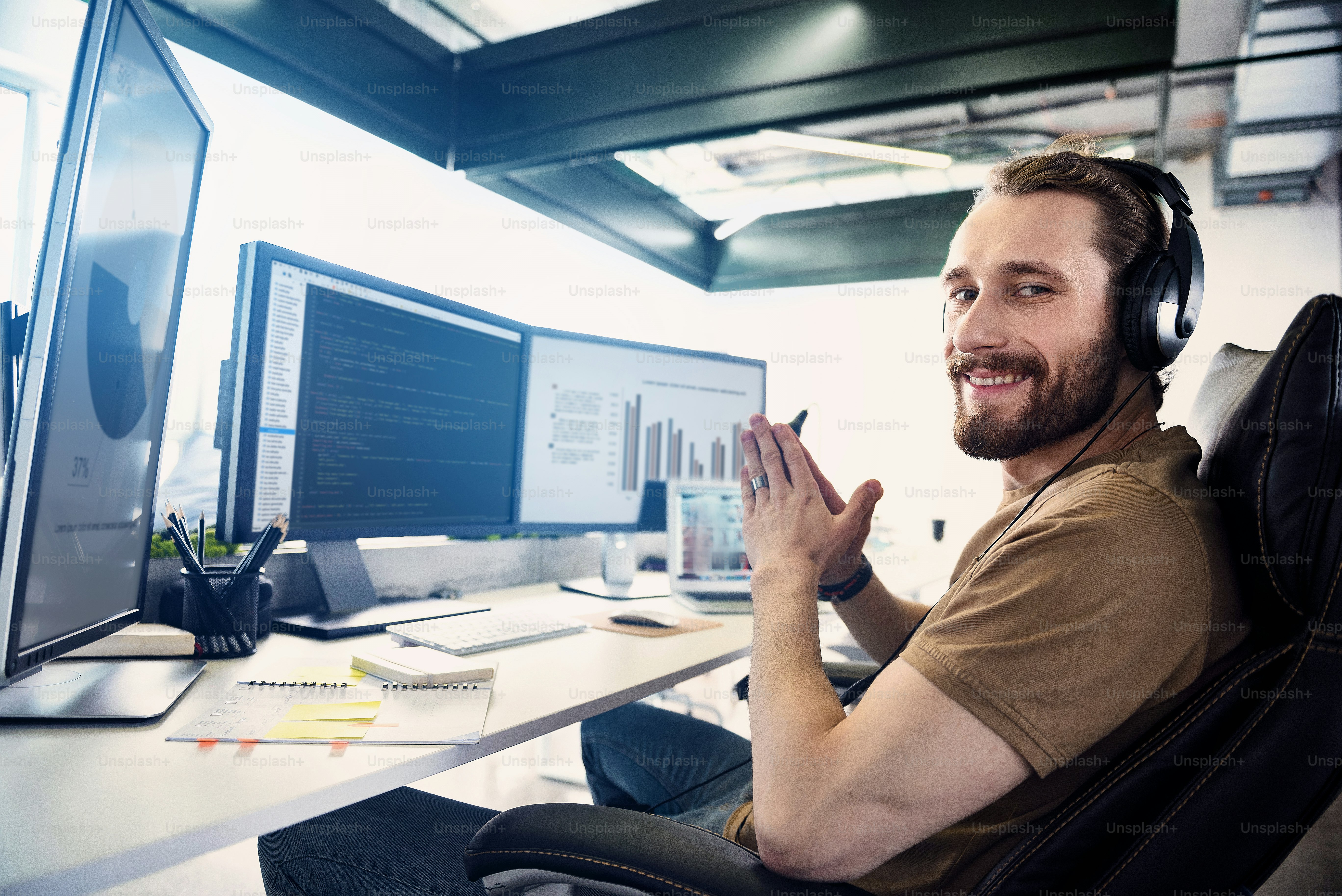 Low angle portrait of outgoing man working on digital device in modern ...