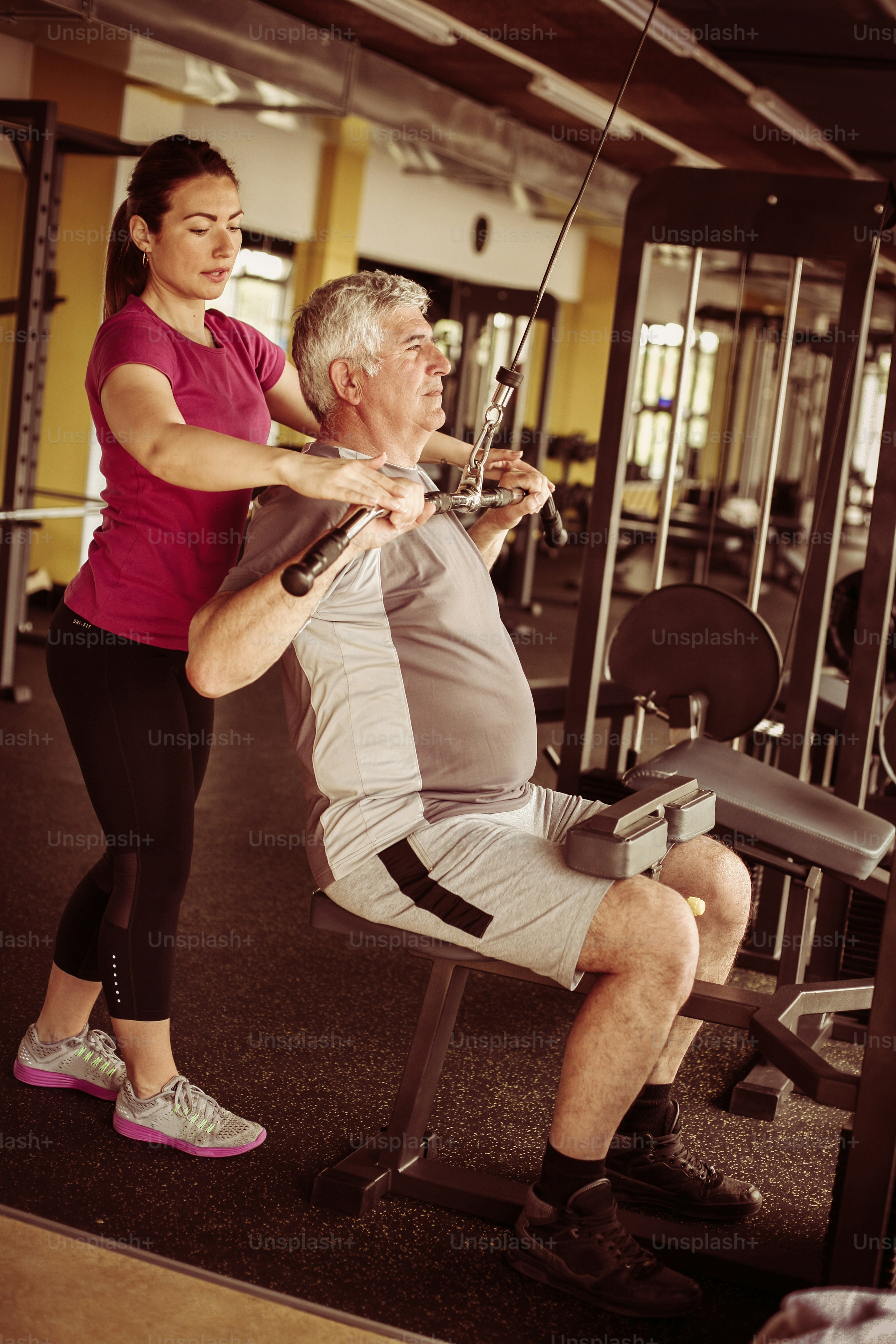 Personal trainer working exercise with senior man in the gym. photo ...