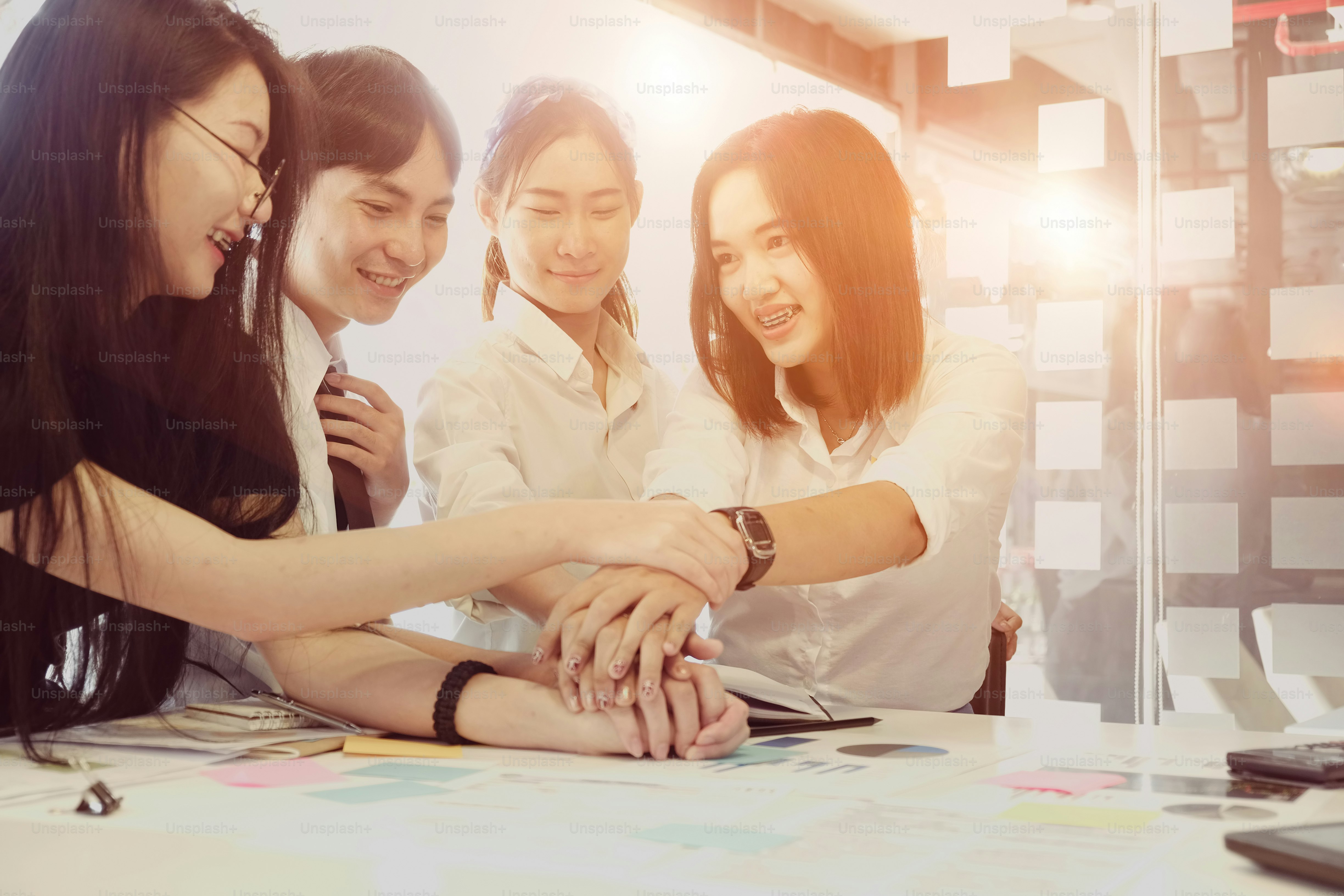 Asian business people making pile of hands. Concept of teamwork. photo ...