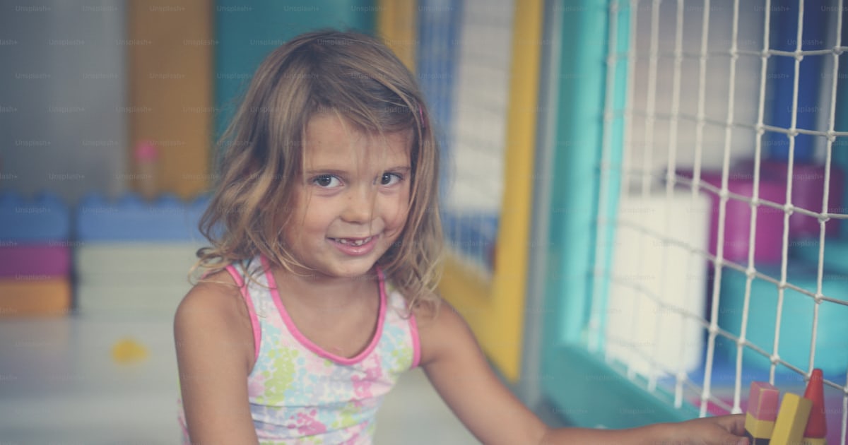 遊び場の小さな女の子。おもちゃで遊んでいる白人の女の子。カメラを見る。の写真 セルビア Unsplashの写真
