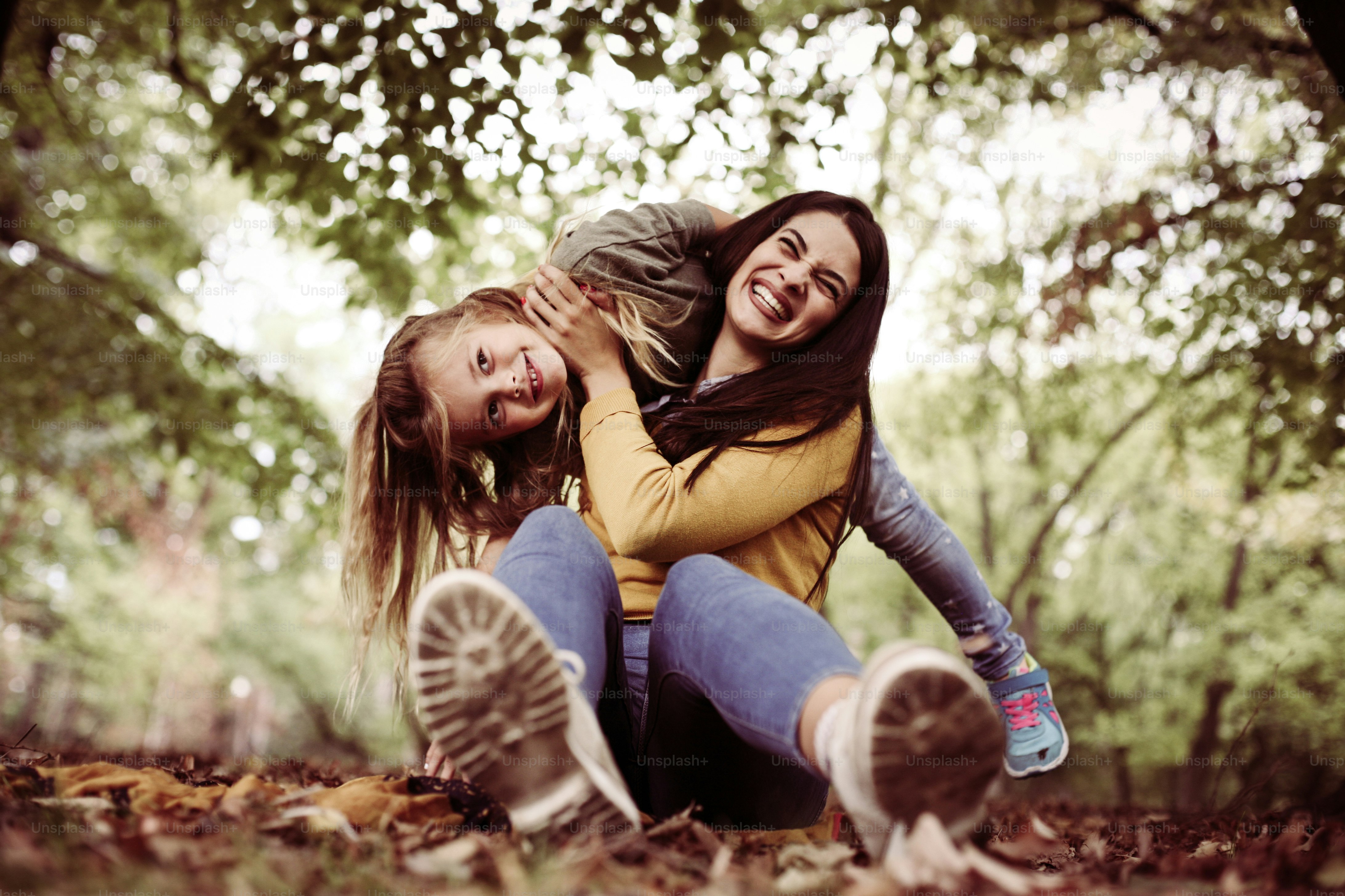 Foto zum Thema Mutter und Tochter auf der Wiese. Kleines Mädchen liegt ...