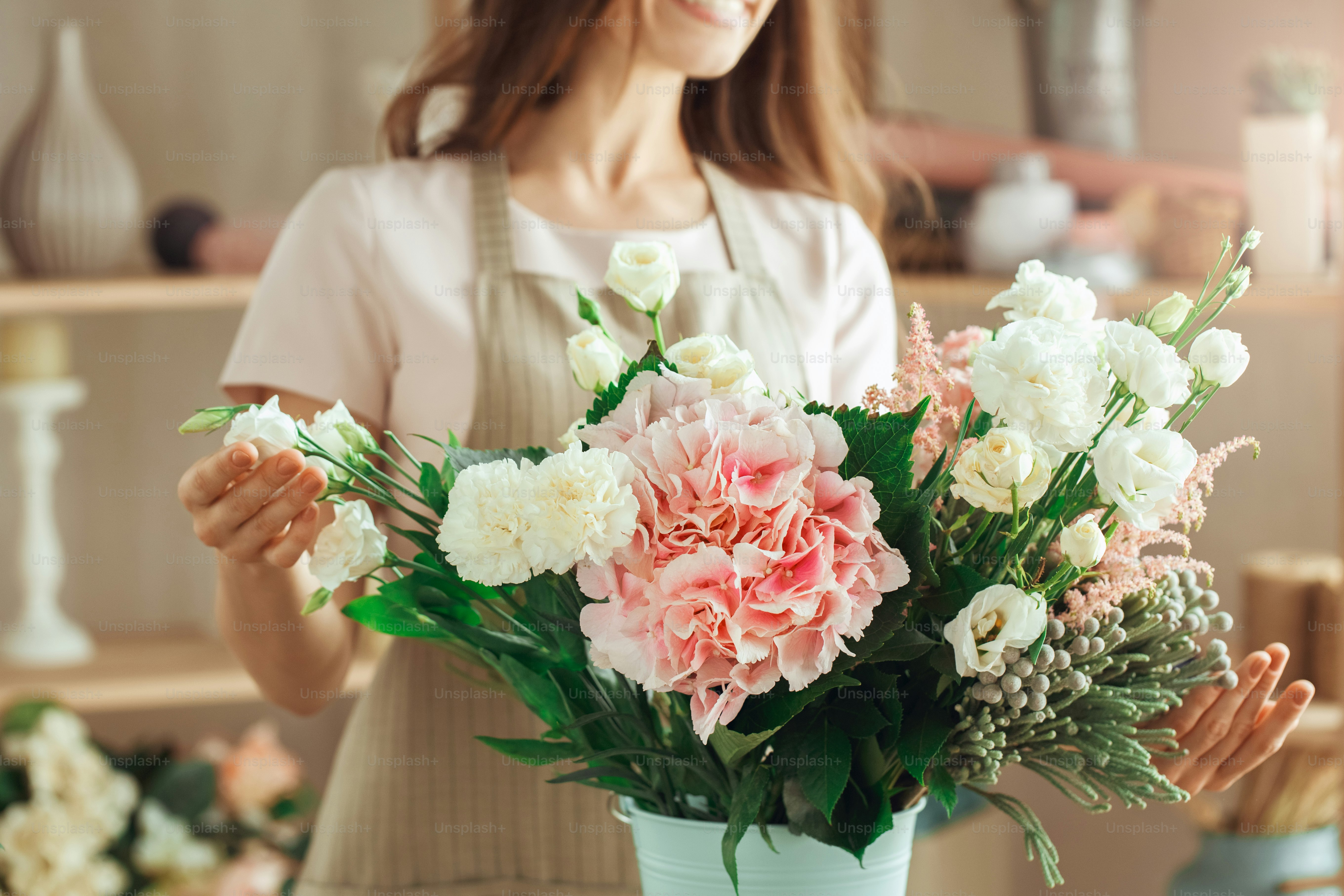 Young female florist working with flowers making bouquet photo ...
