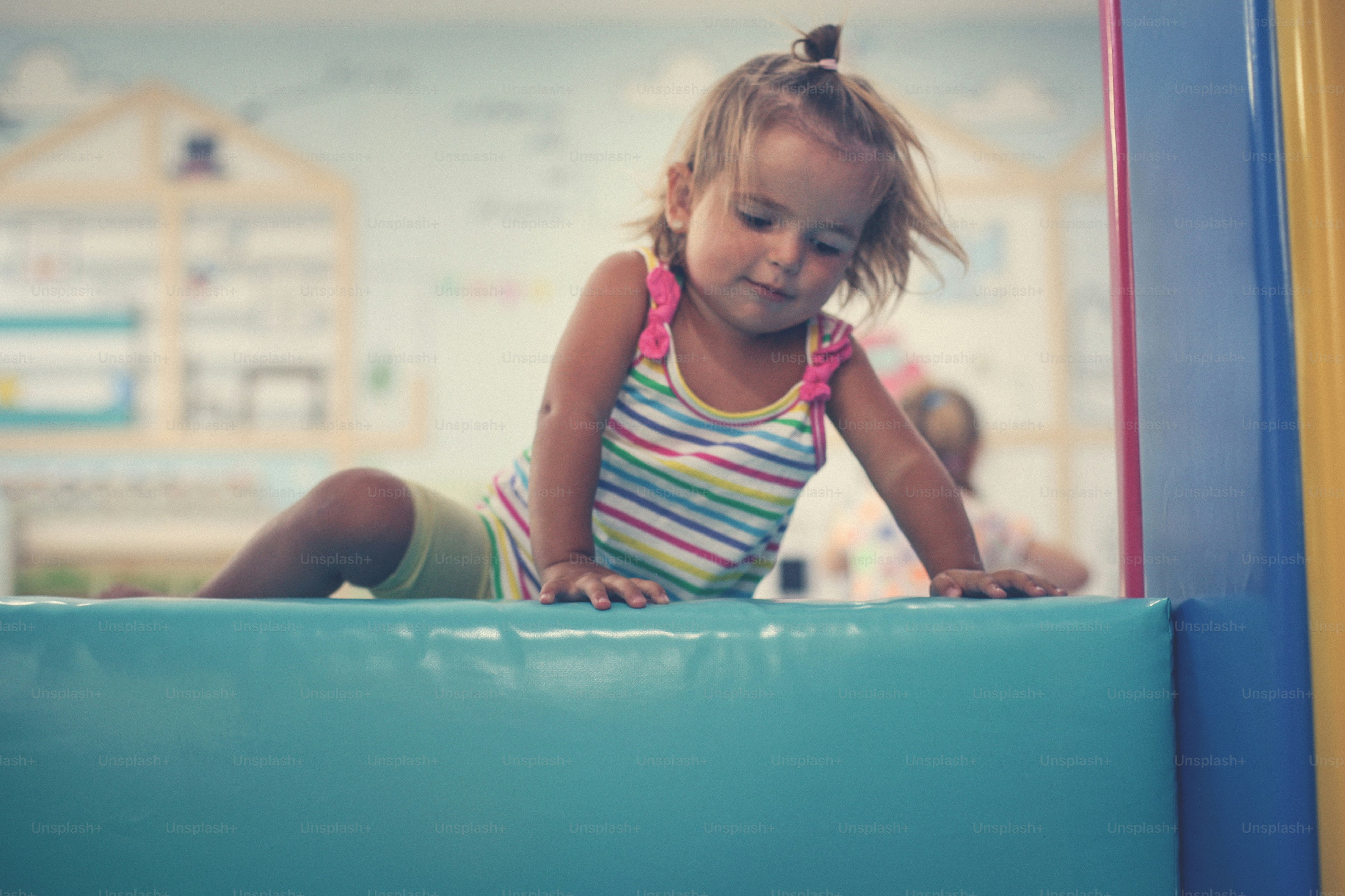 Pequeño bebé caucásico en el patio de recreo. Feliz bebé escalando ...