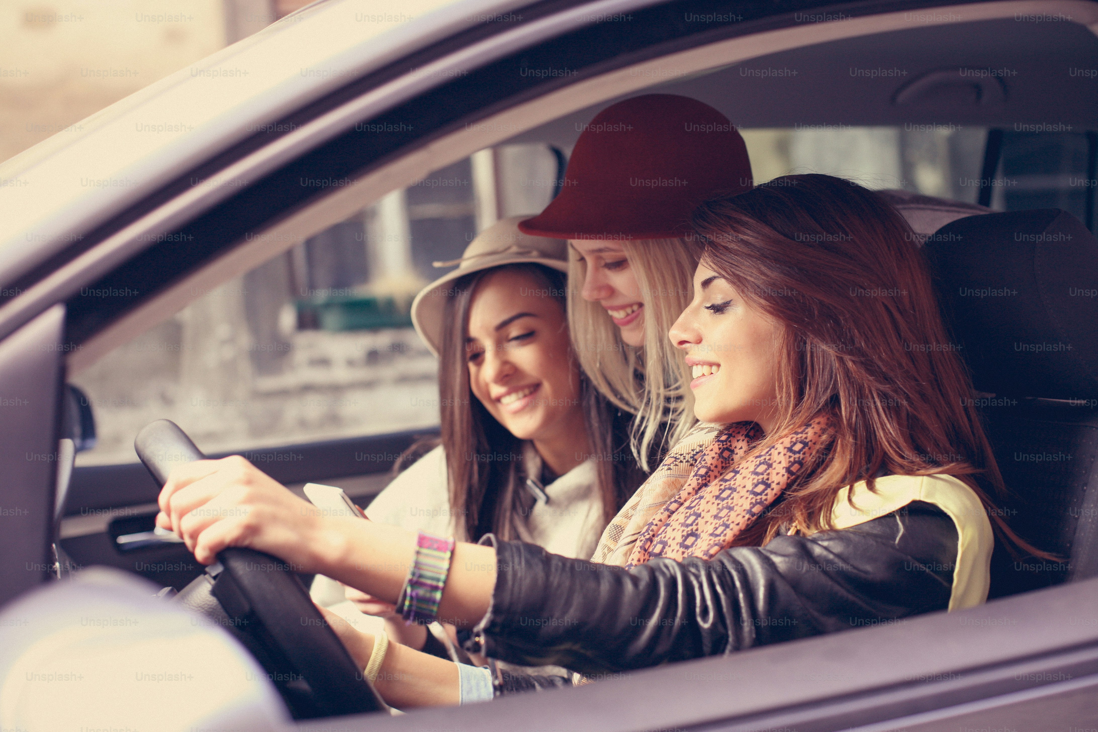 Three best friends in the car and reading message on smart phone. photo ...