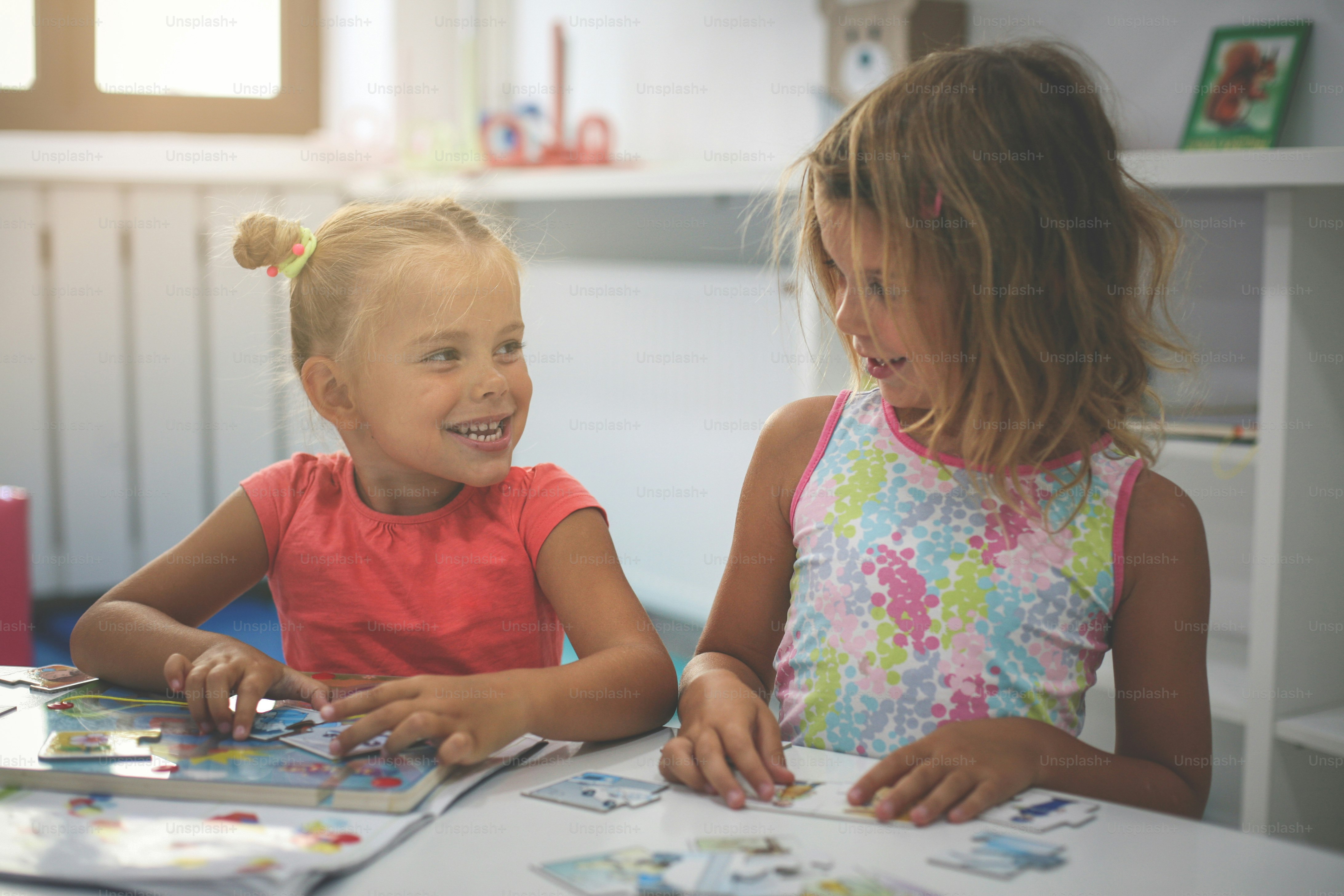 Two little girls playing together in playground. Two sisters they are ...