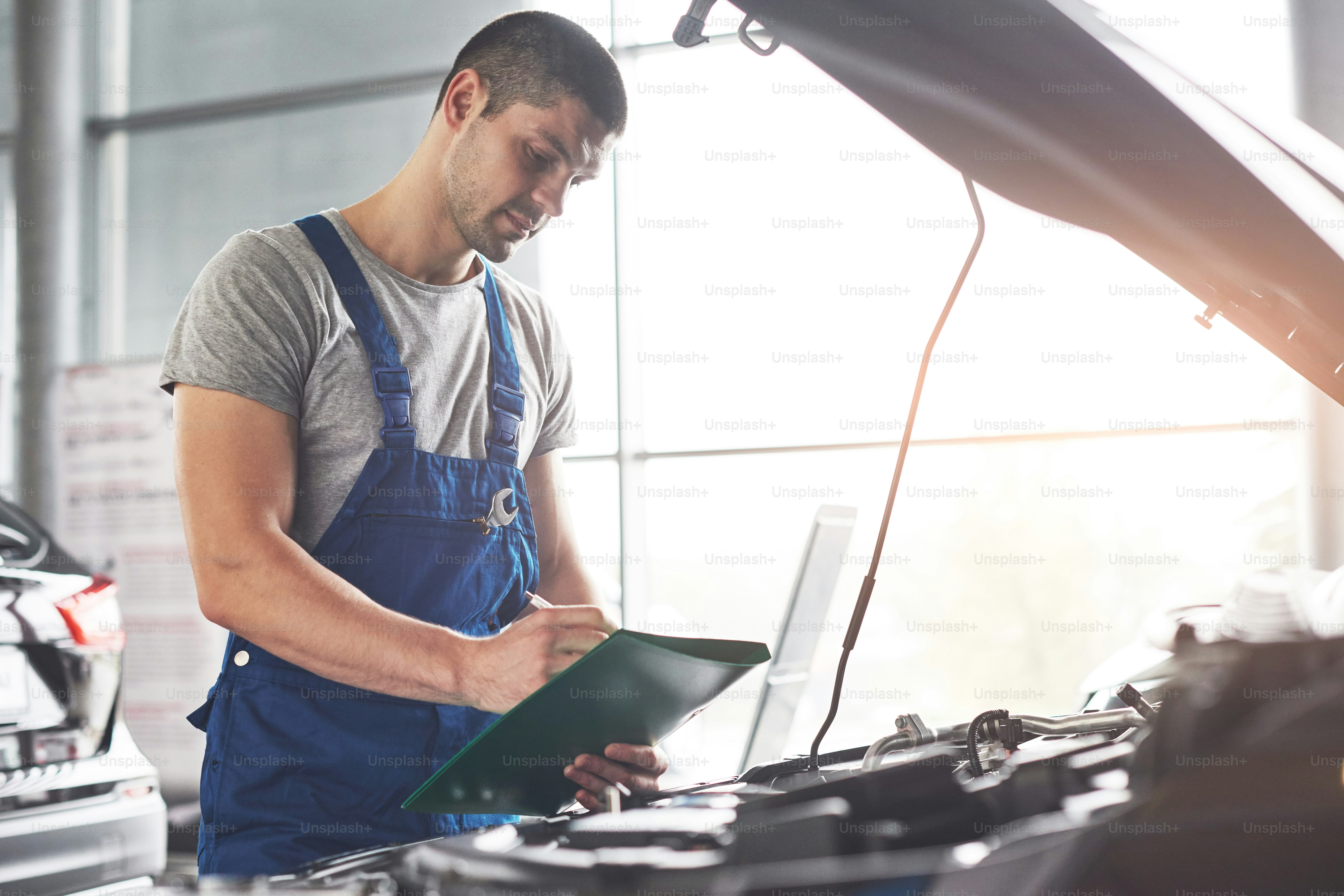 Picture showing muscular car service worker repairing vehicle. photo ...