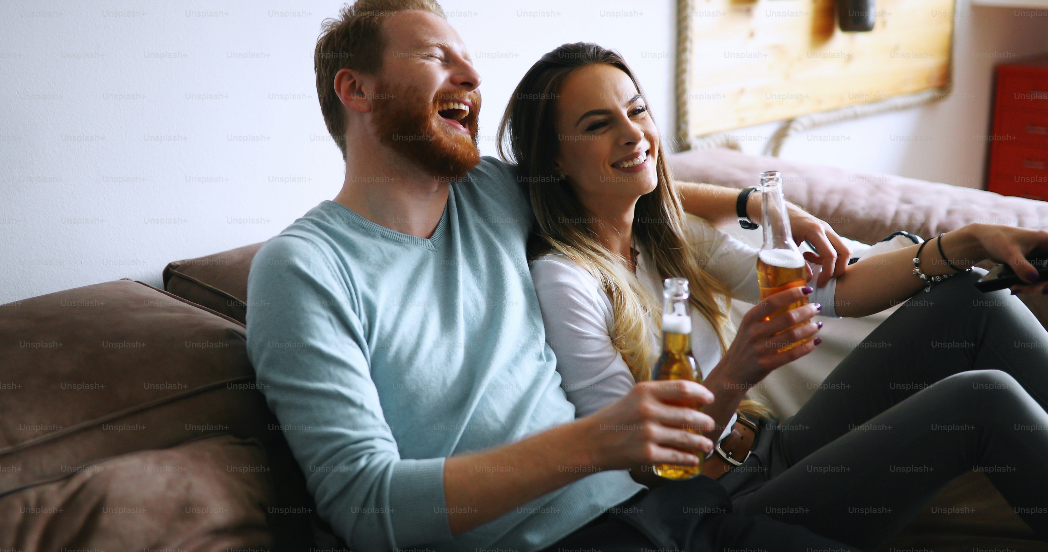Romantic couple in love drinking beer together and watching tv photo ...