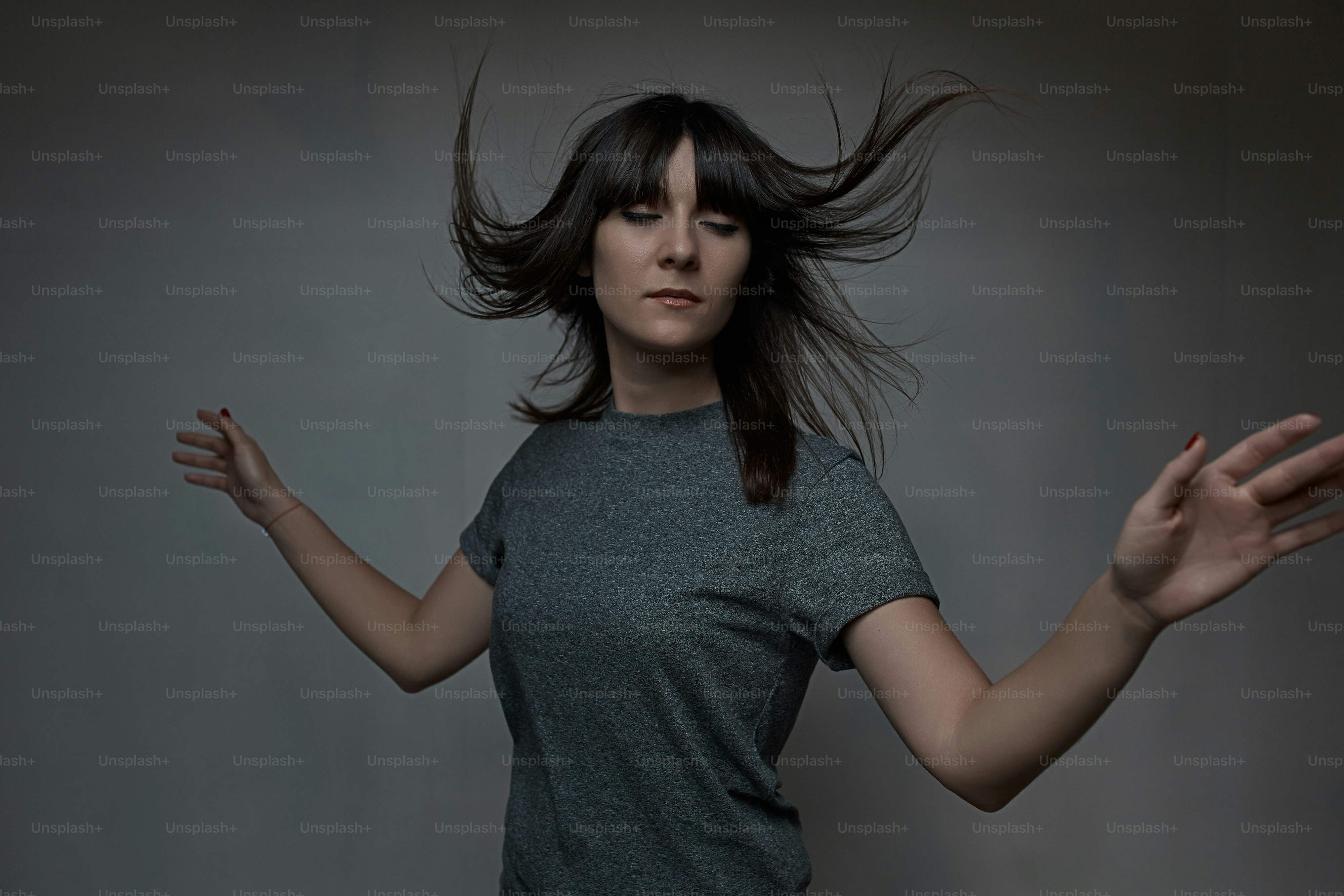 Making magic. Beautiful girl with flying hair in the wind moving hands ...