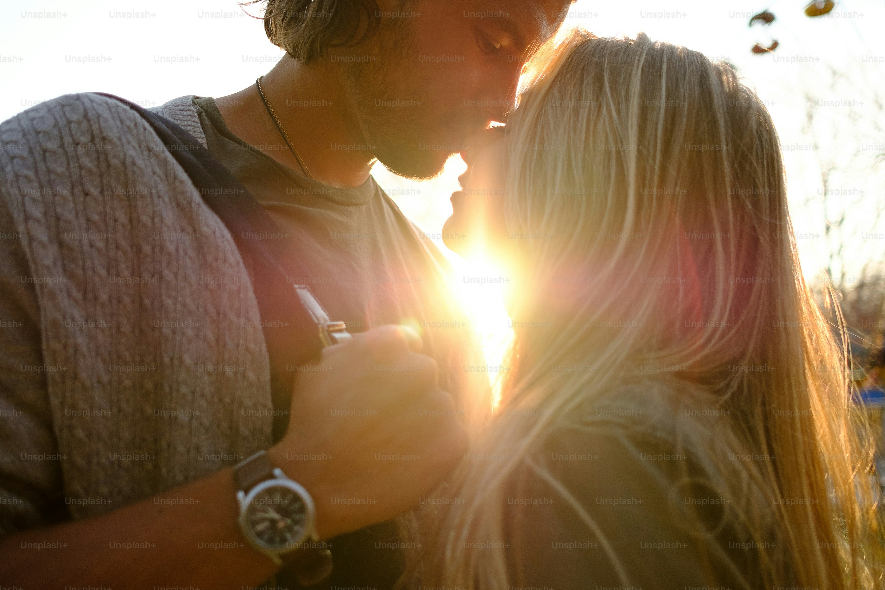 Happy smiling couple in love hug and kiss each other in the amusement ...