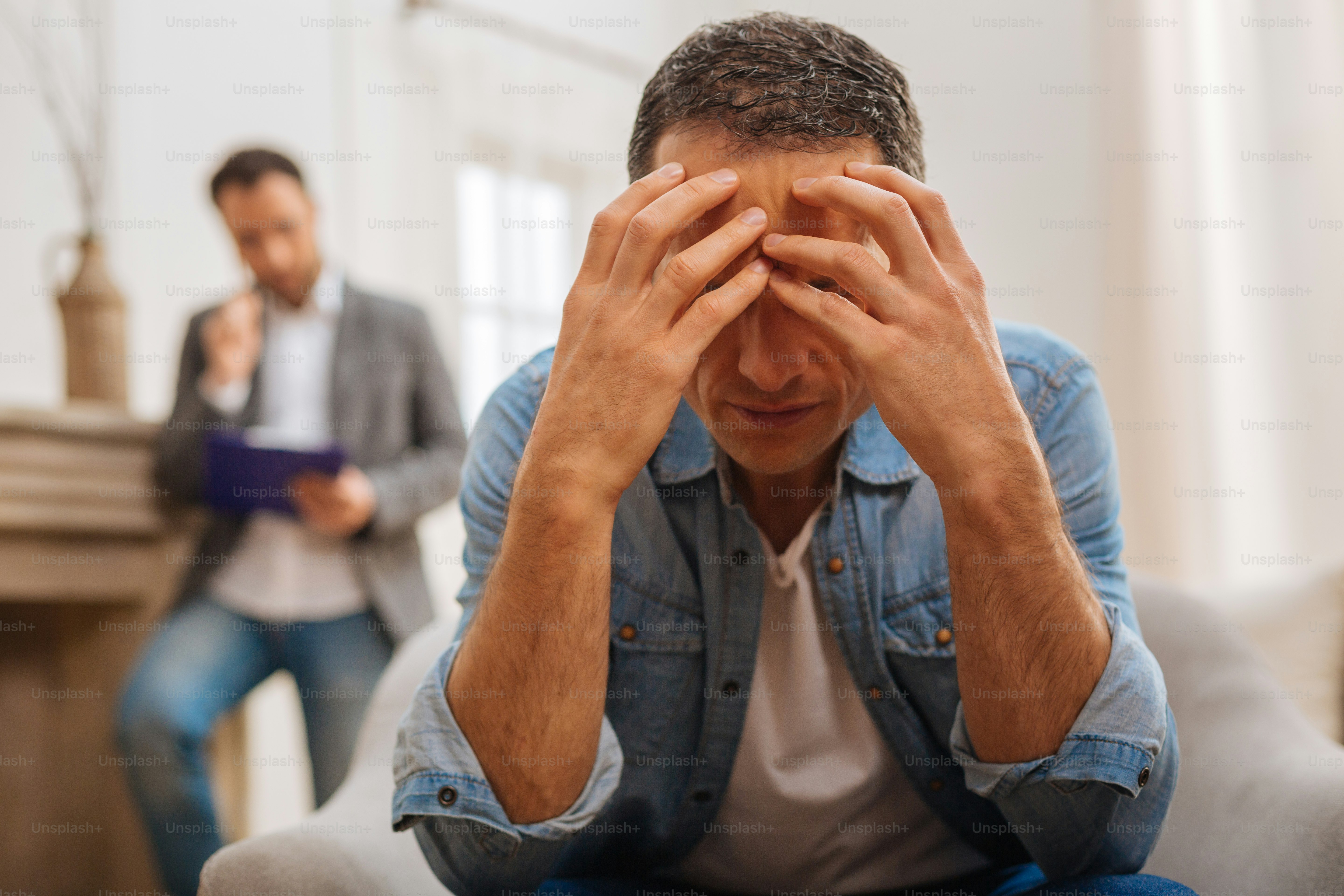 Life obstacle. Upset disturbed male patient putting his hands on the ...