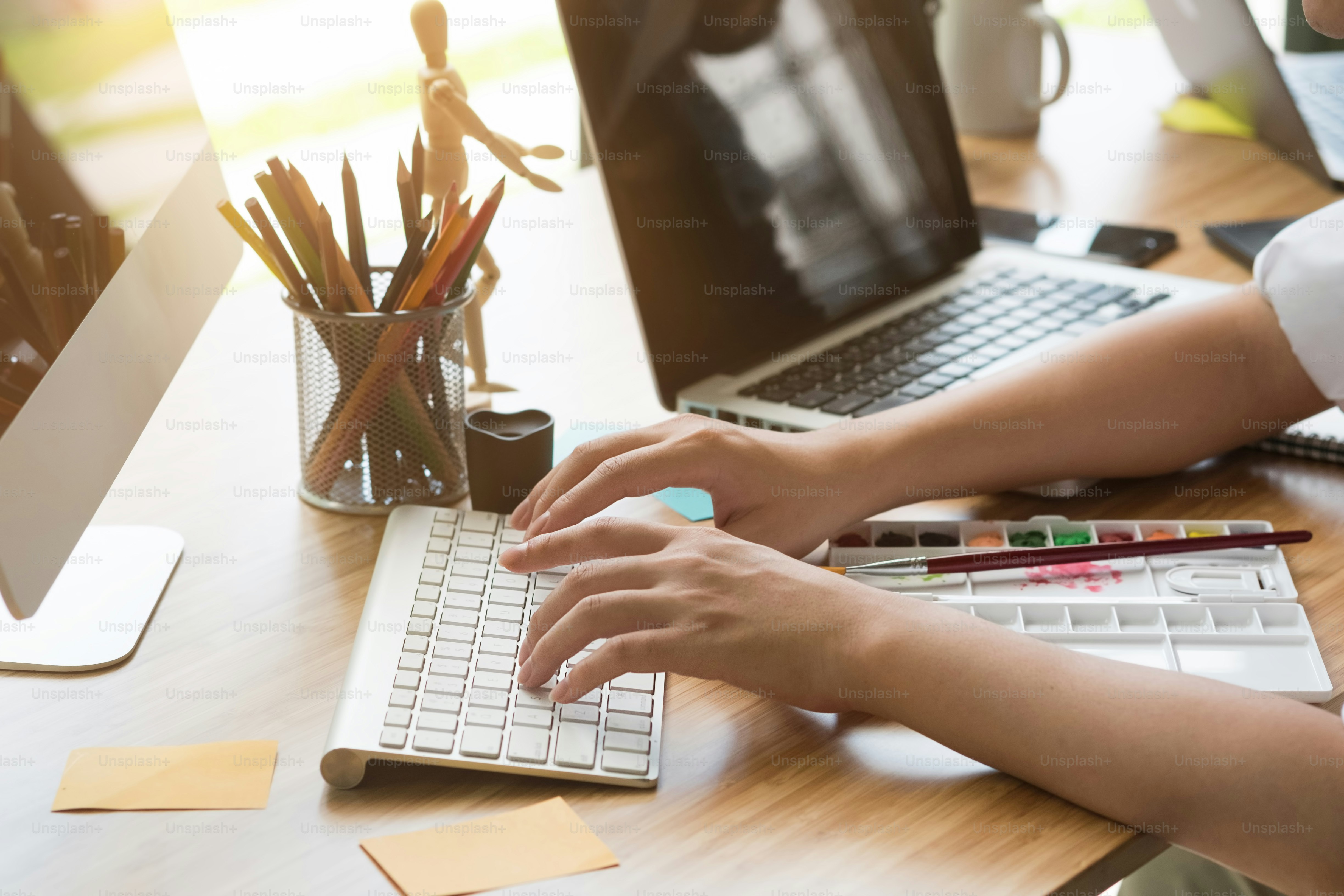 Working on computer hands typing computer keyboard in artist studio ...