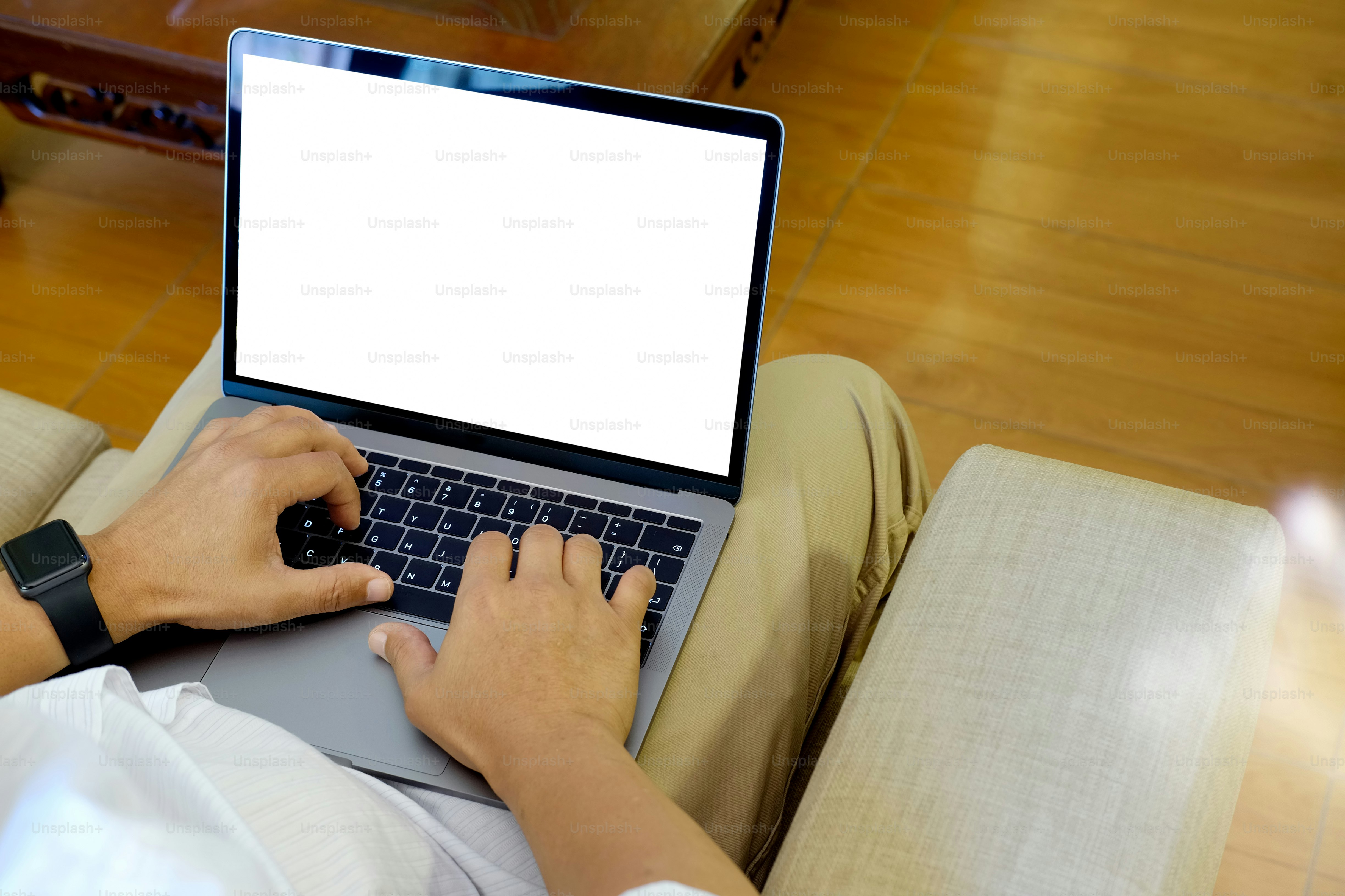 Closeup shot of an unidentifiable man using a laptop at home office ...