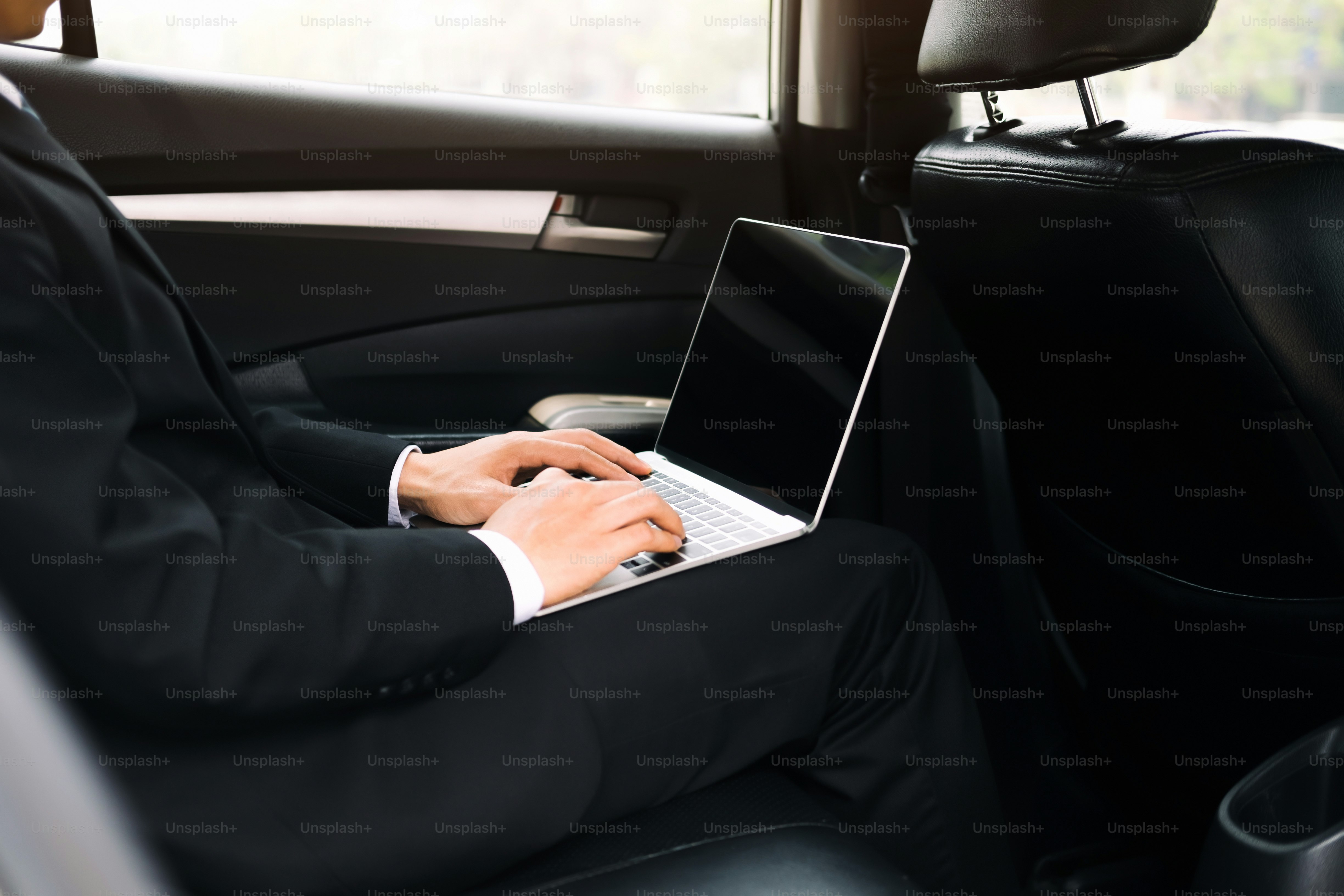 Businessman using computer working car inside. photo – Businessman ...