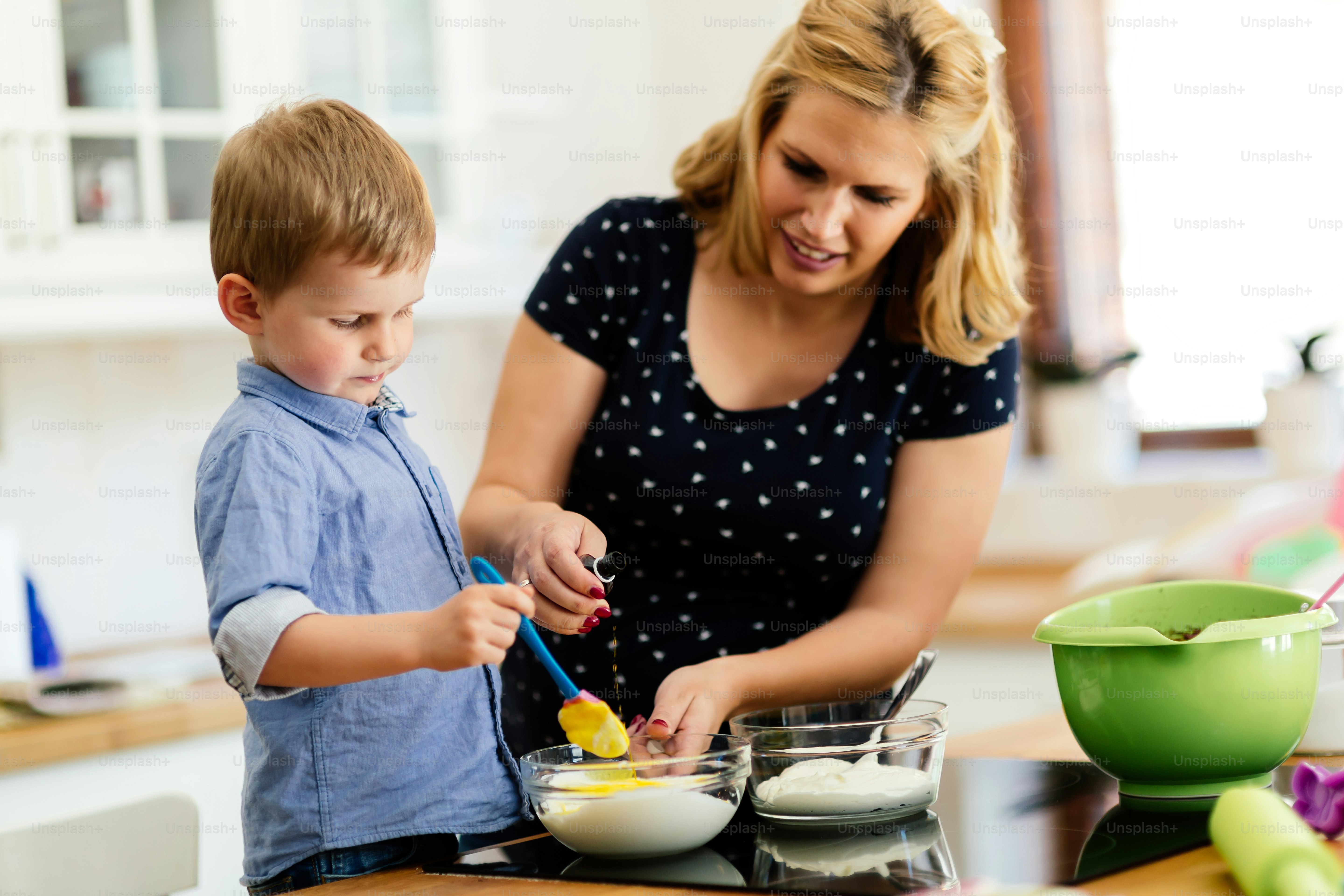 Child helping mother prepare muffins in kitchen photo – Mother and son ...