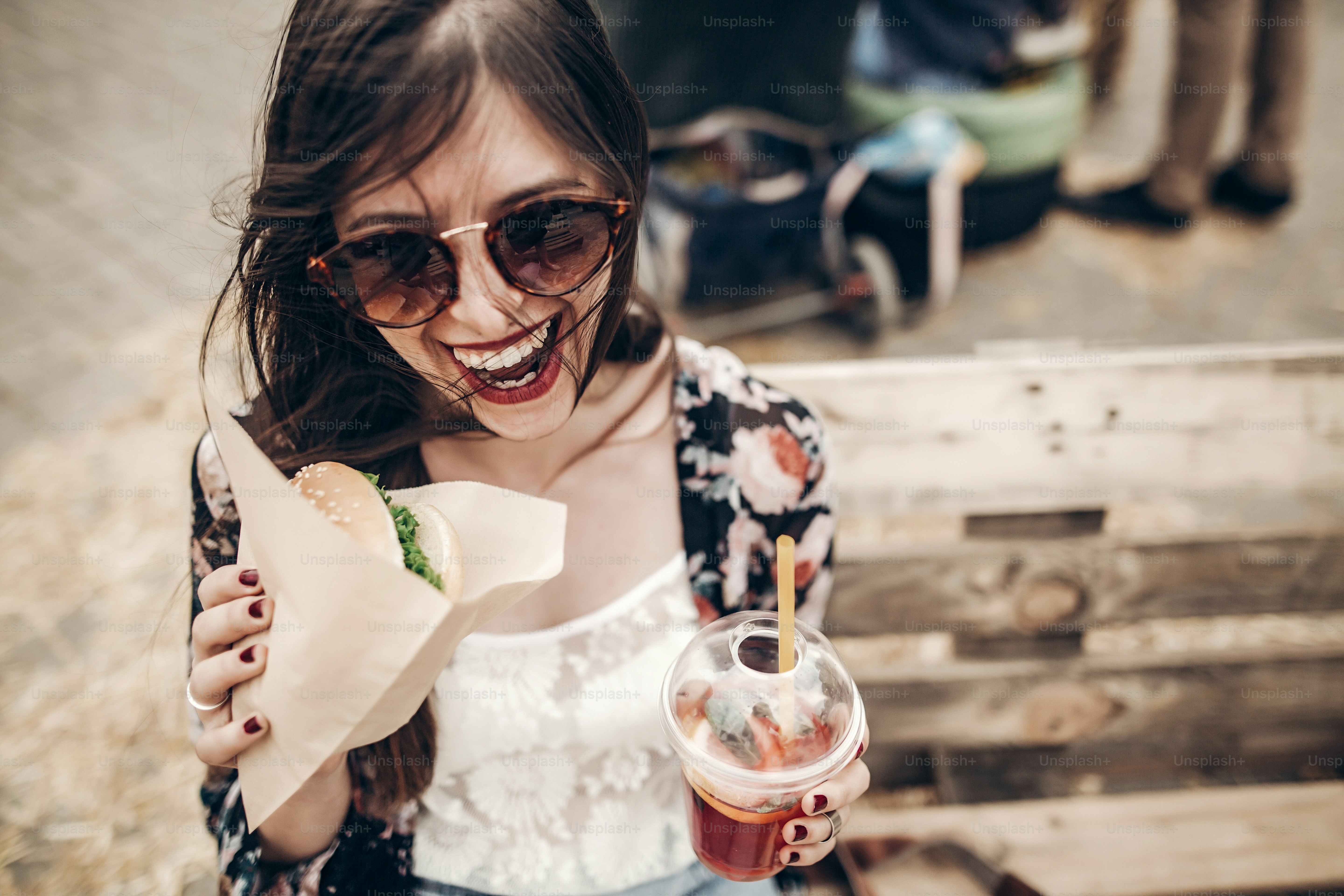 Stylish hipster woman holding juicy burger and lemonade, eating. boho ...
