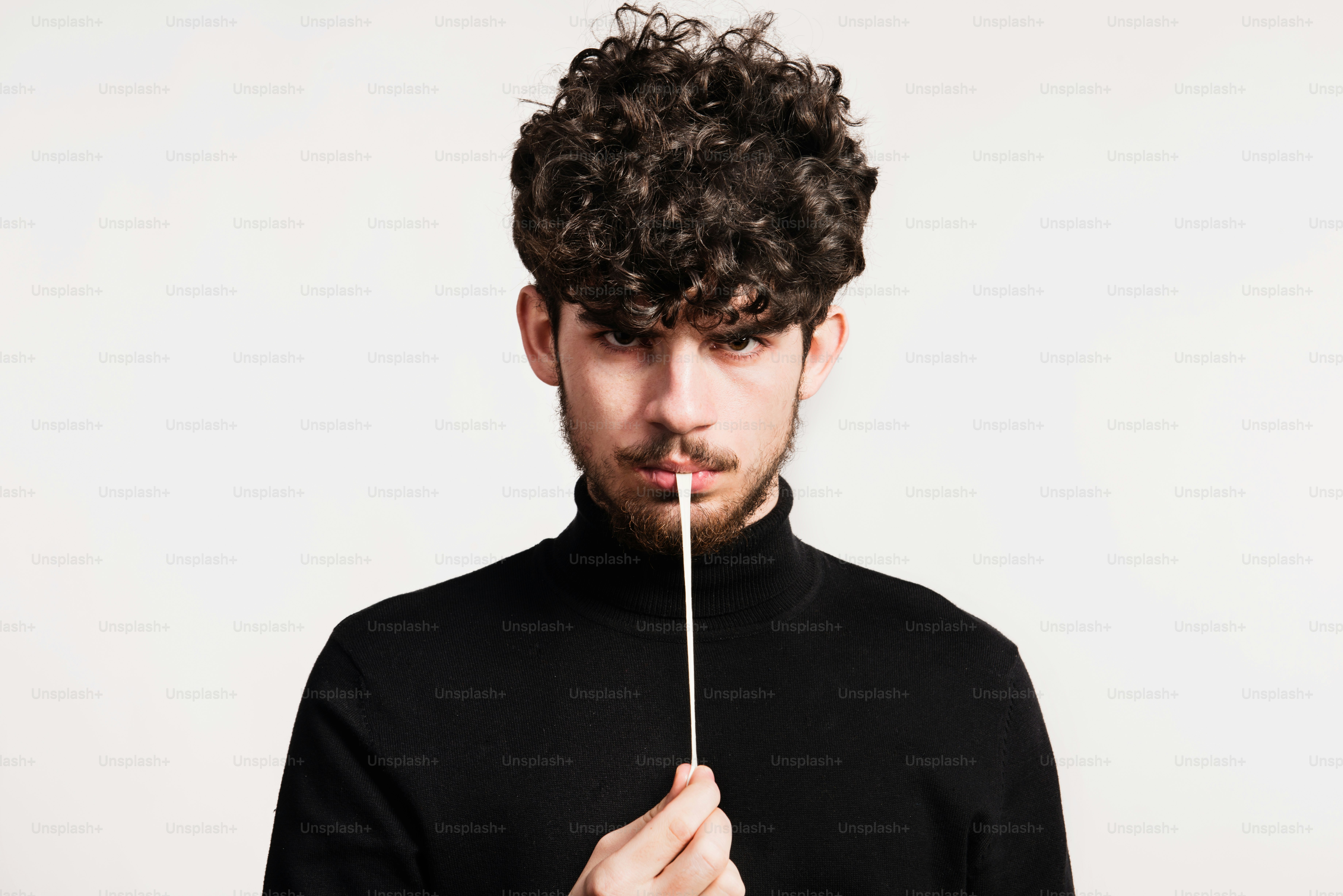 Portrait of a young man in a studio, pulling a chewing gum. photo ...