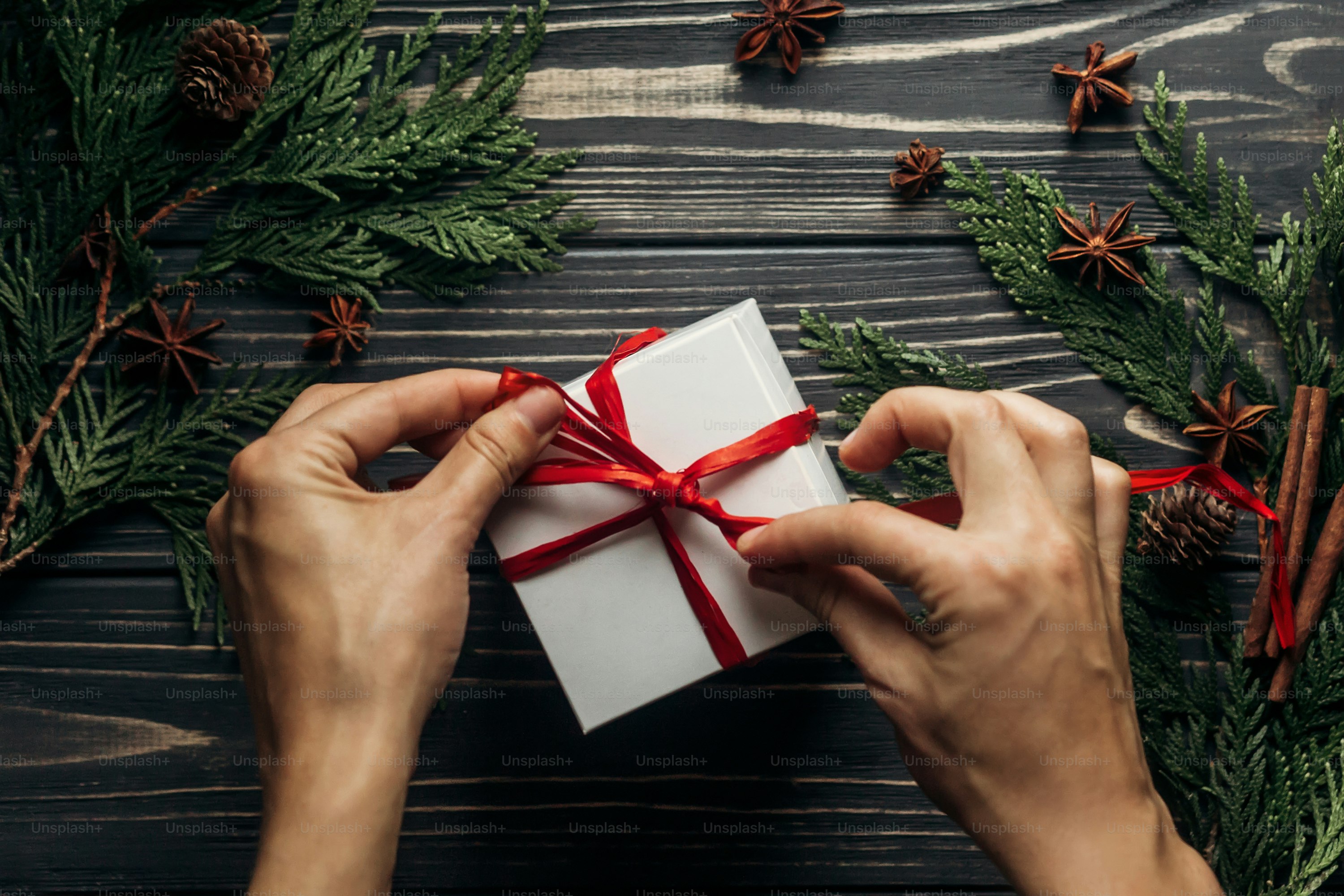 Foto Elegante piso de Navidad con las manos envolviendo el presente con ...