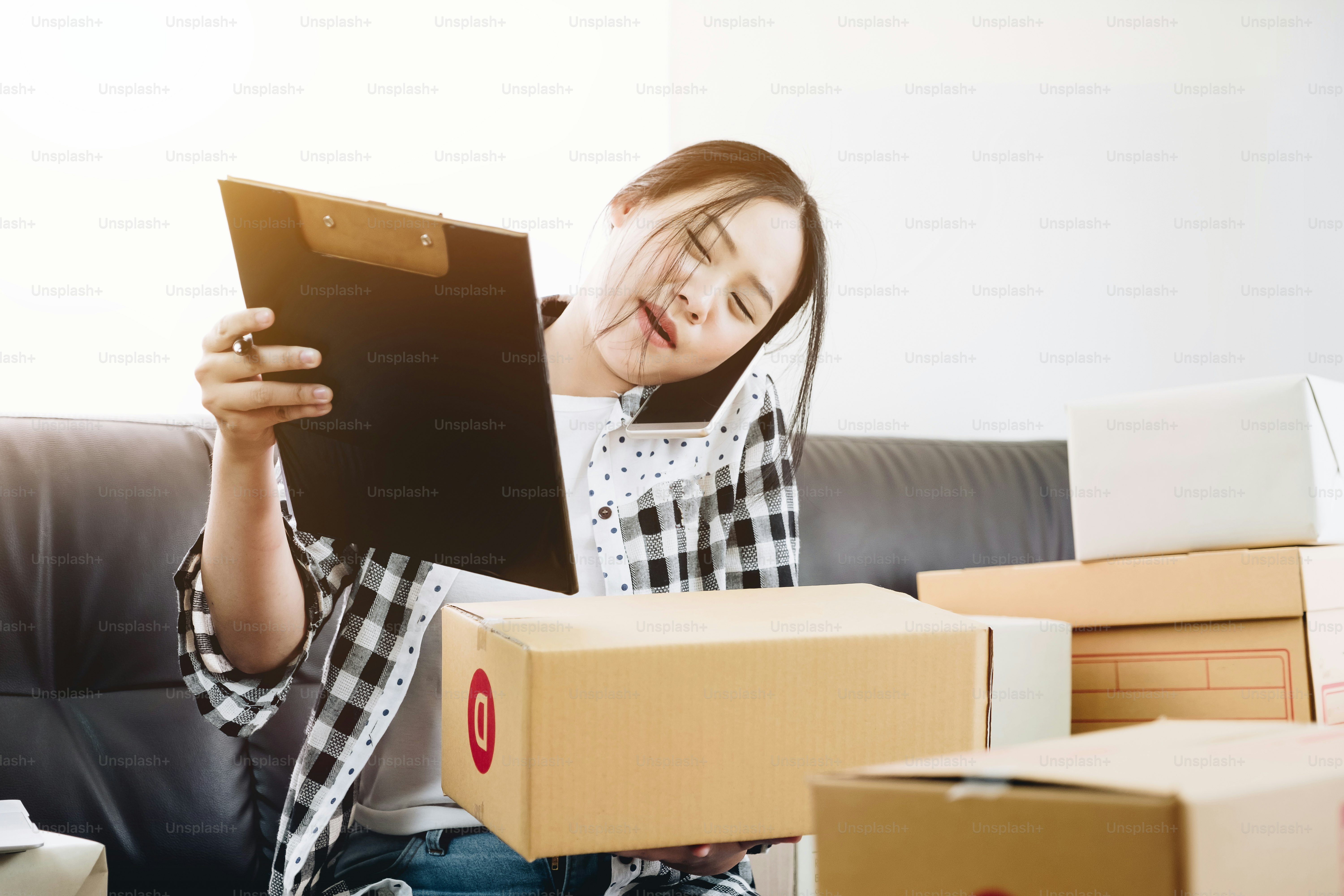 Portrait of an busy young woman and small business owner using her ...