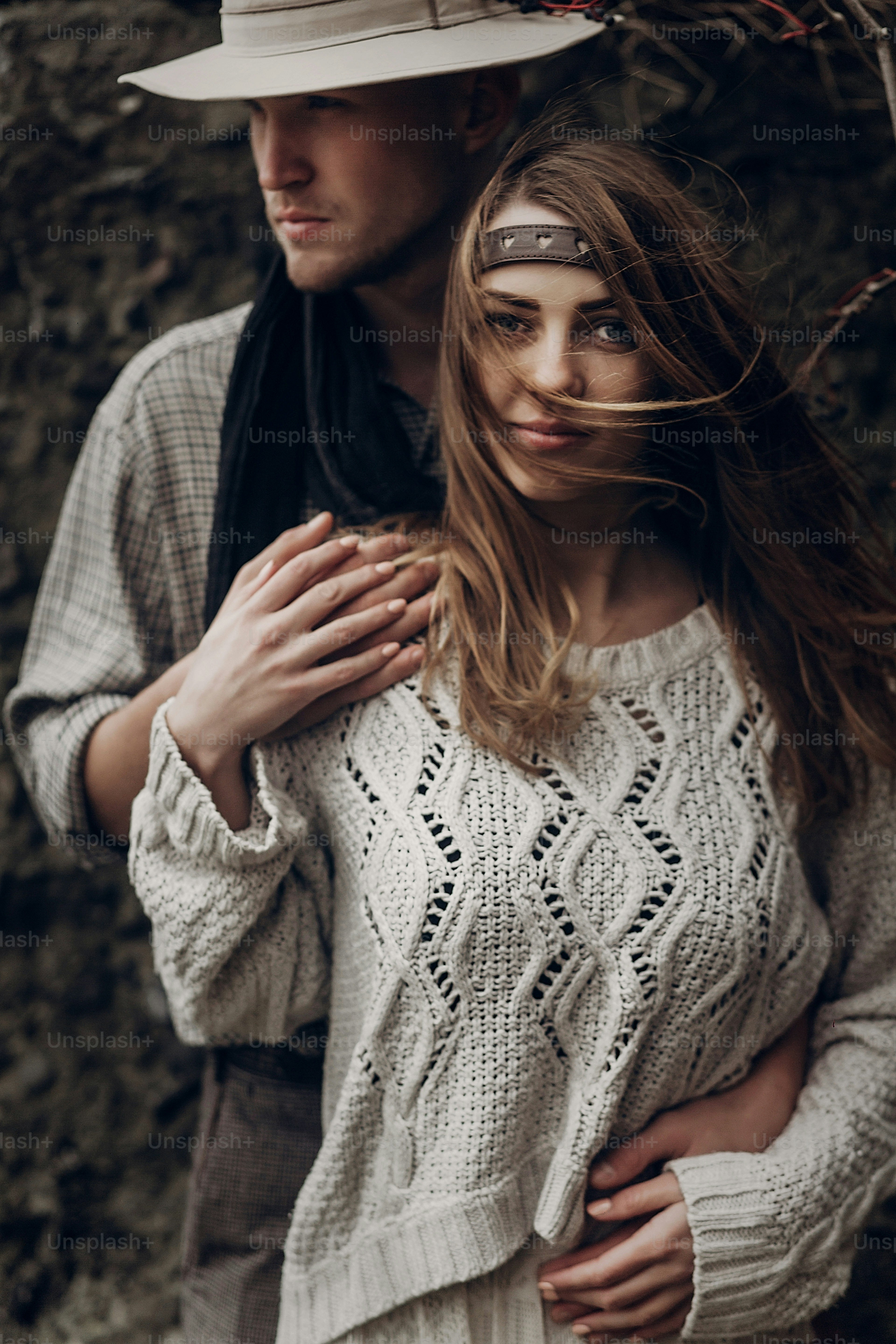 Belle fille gitane brune, femme hipster en pull blanc bohème se tenant la main avec un bel homme ...