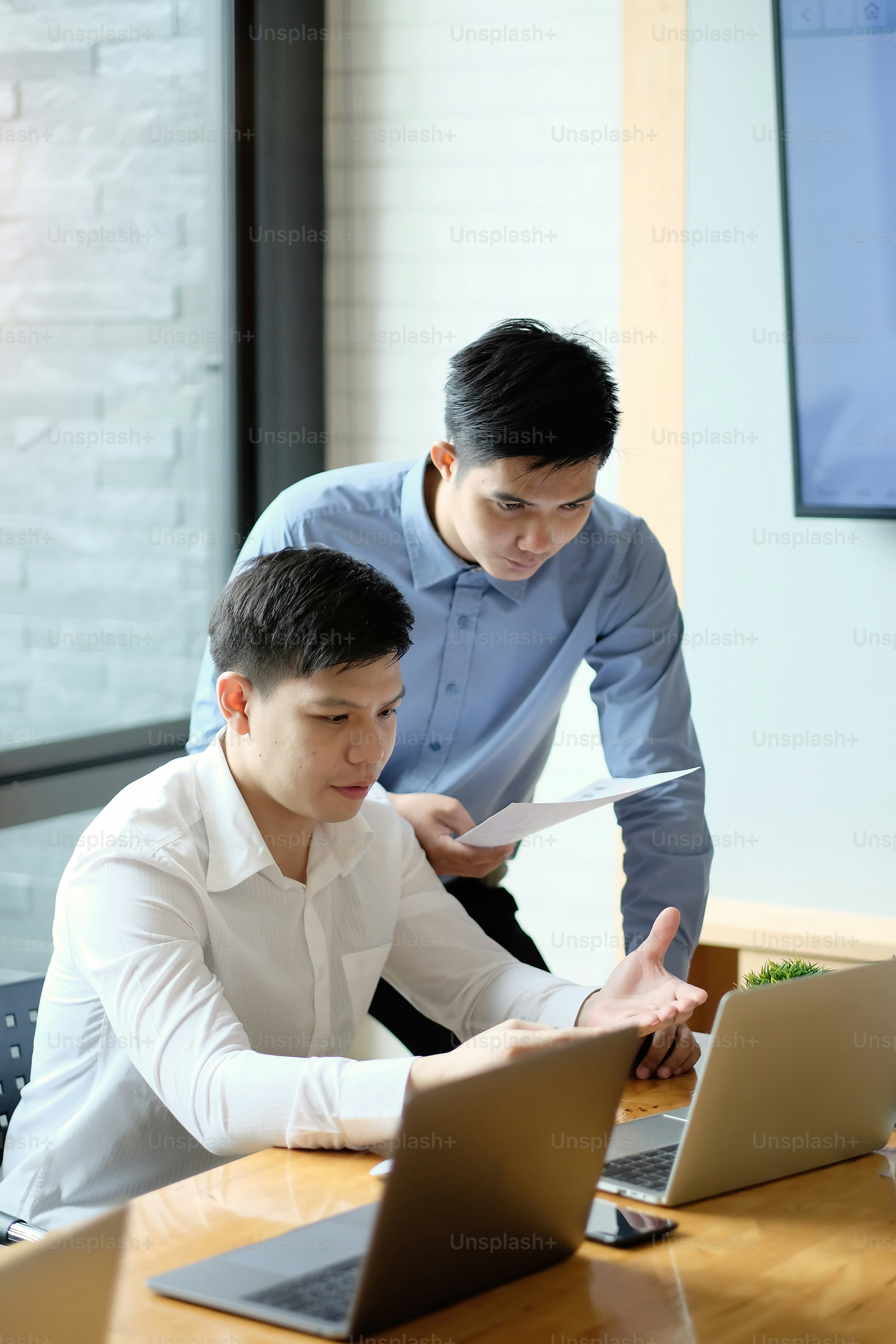 Business partner working with laptop, Two colleagues discussion with ...