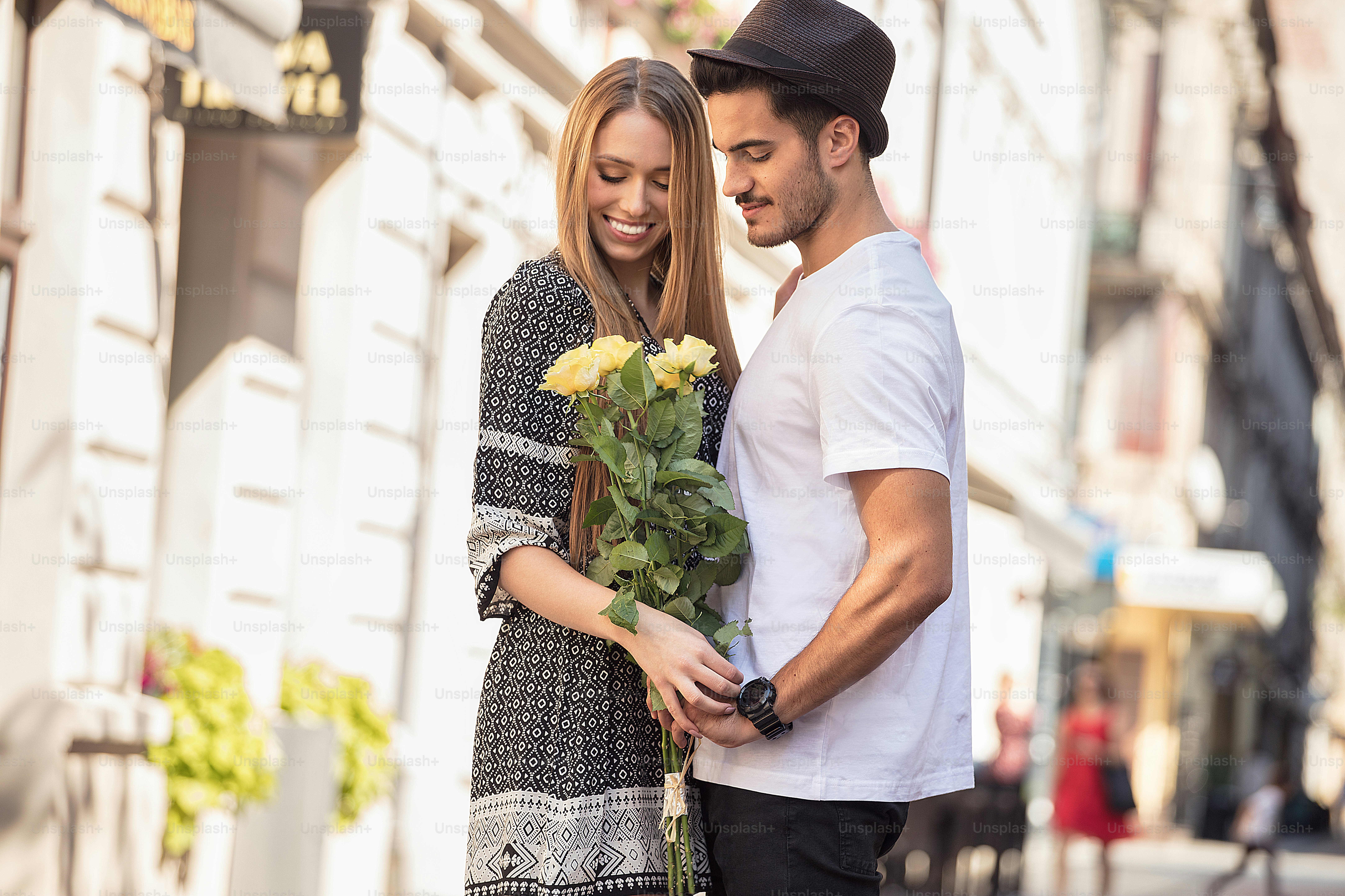 Beautiful young couple with bouquet of roses dating outdoors. Happy ...