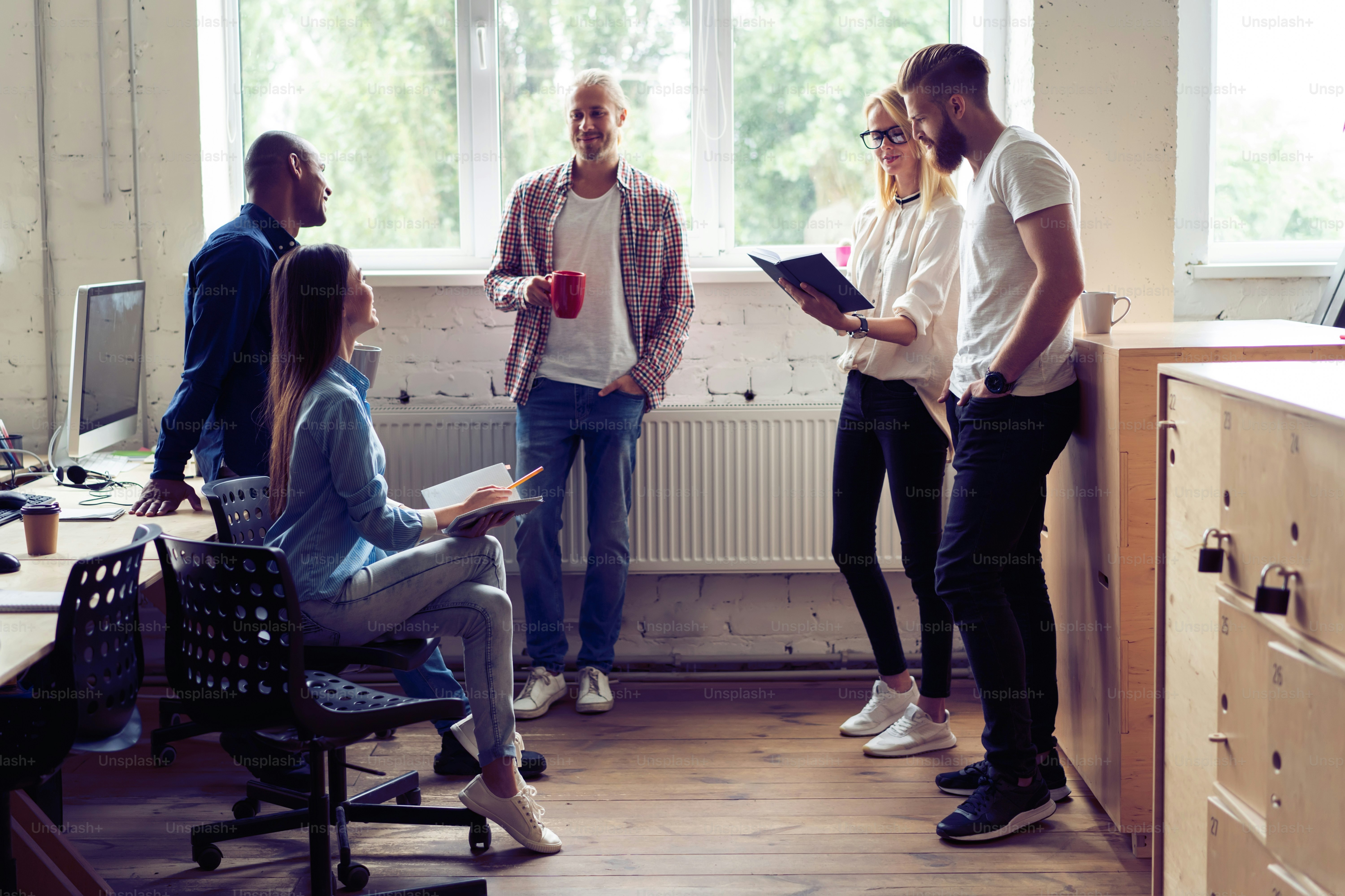 Happy to work together. Group of young business people communicating ...