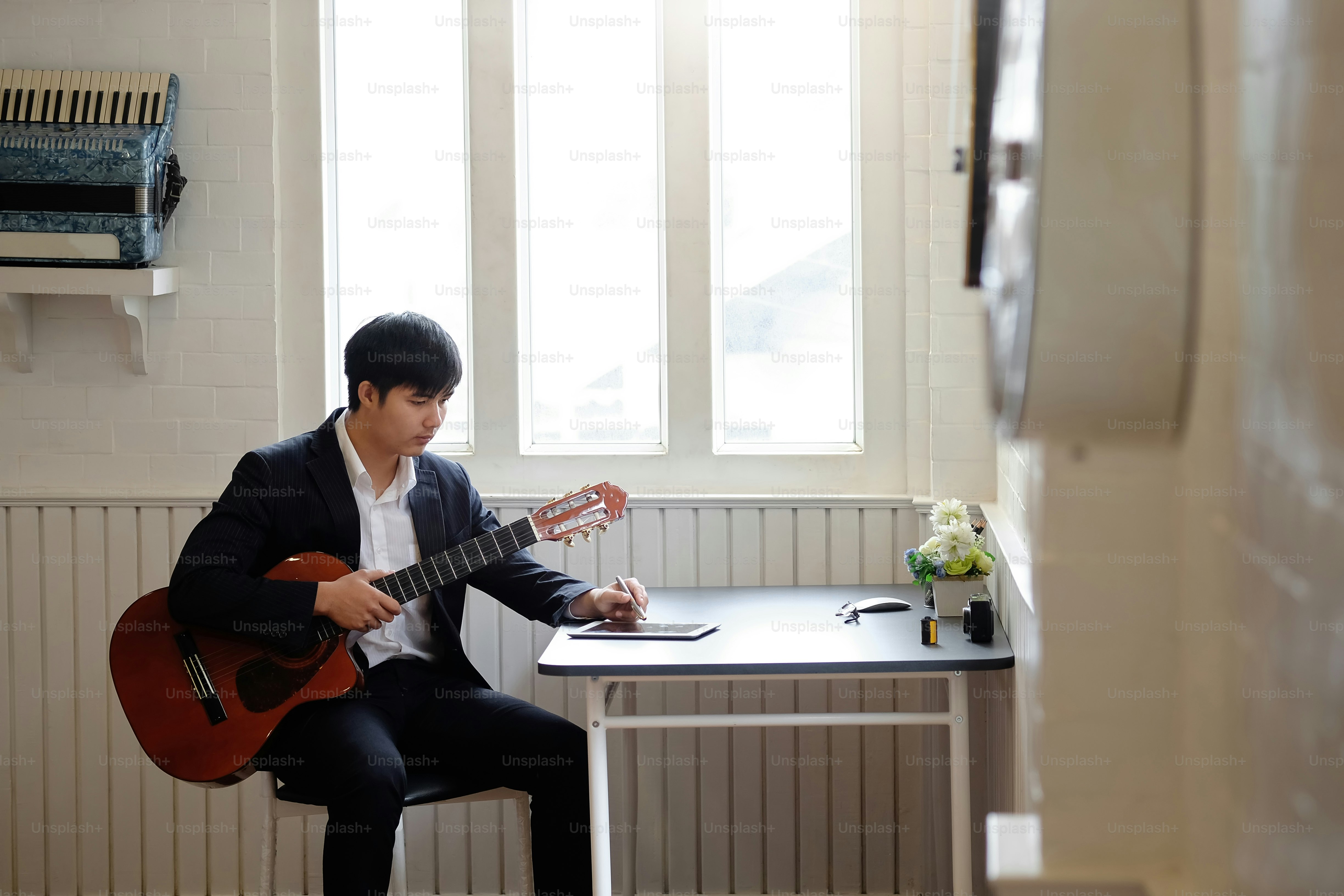 Song writer working, A man using tablet and guitar on artist workplace ...