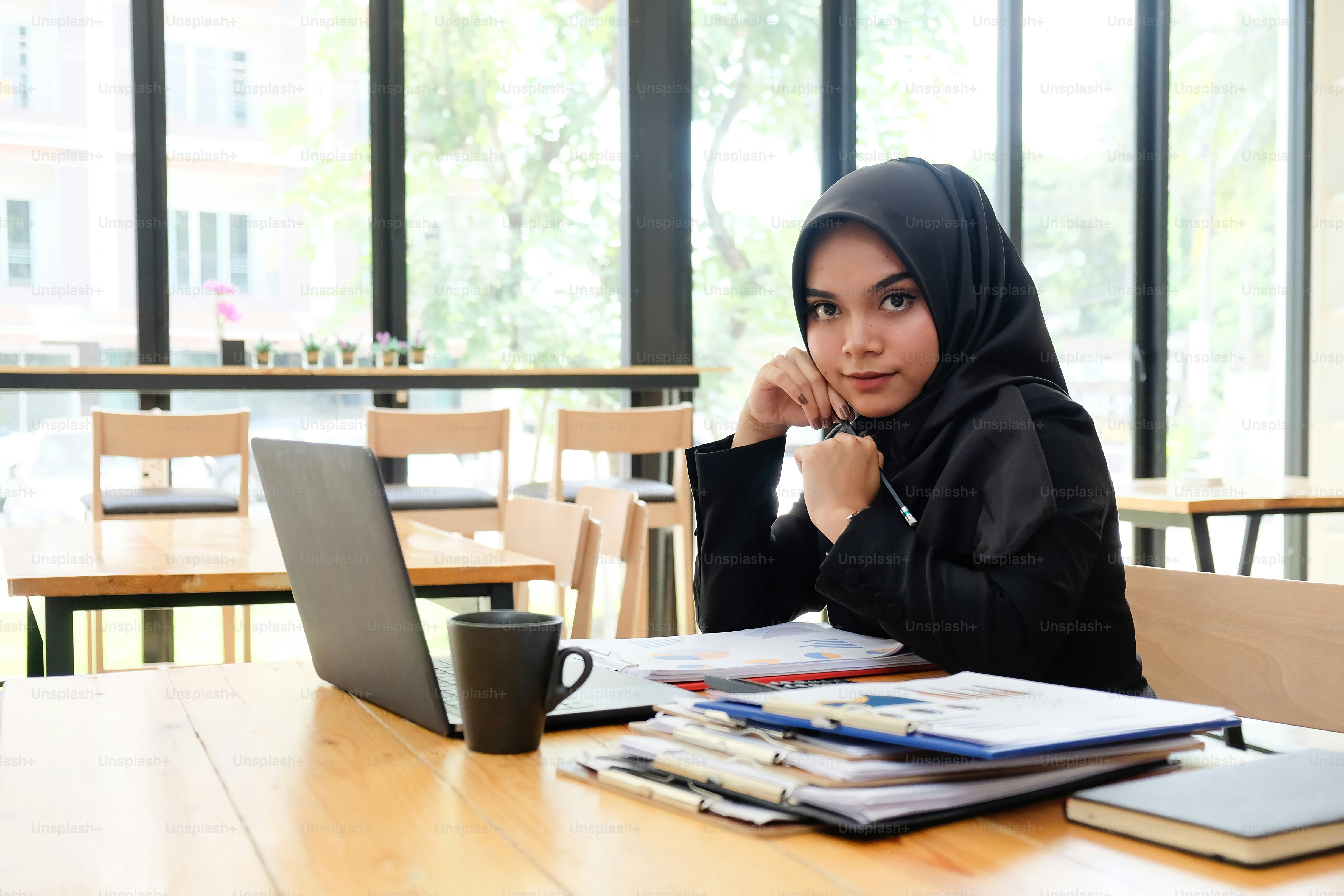 Islam woman working in cafe with portrait shot on table. Working woman ...