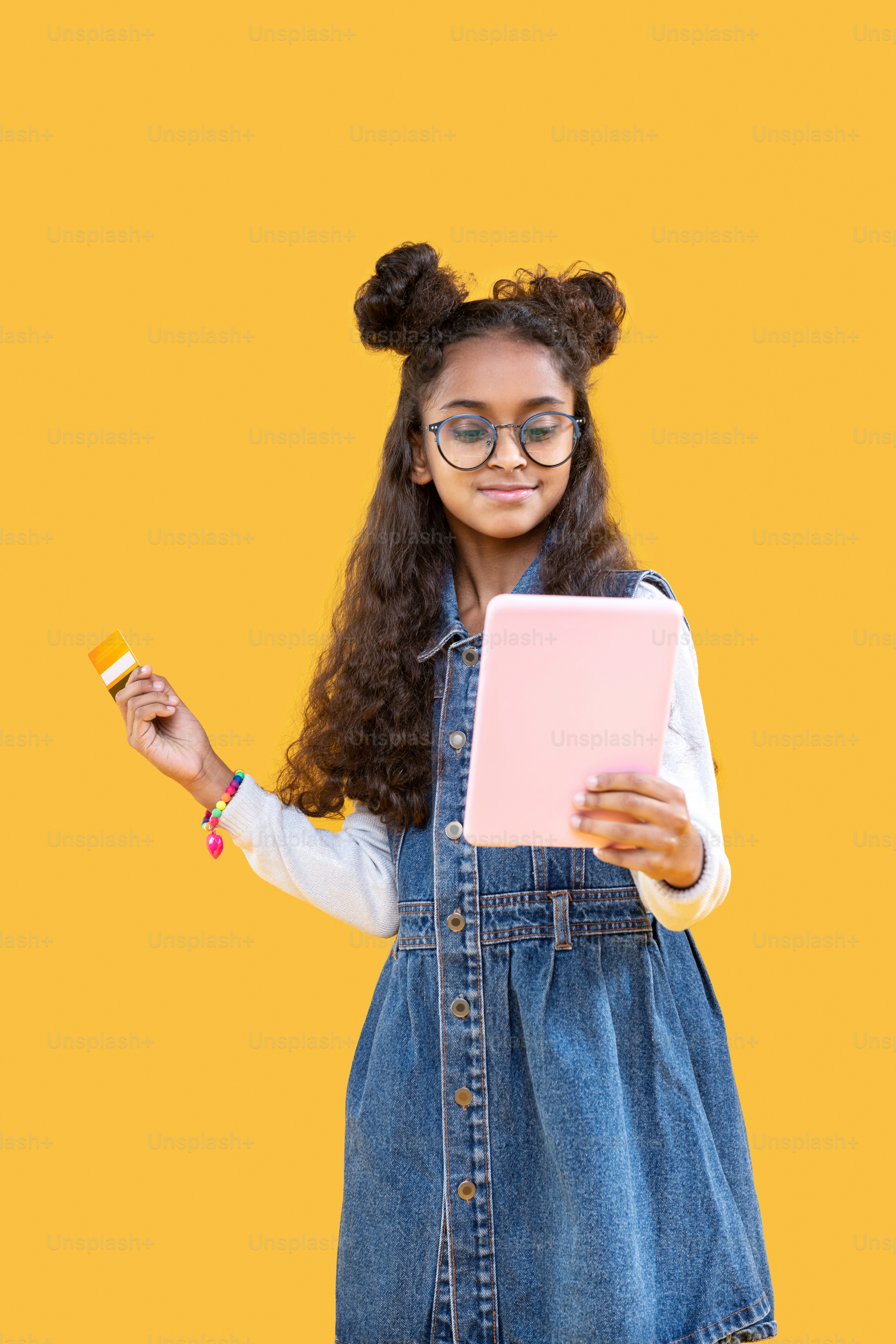 Digital age. Positive smart girl using a debit card while doing ...