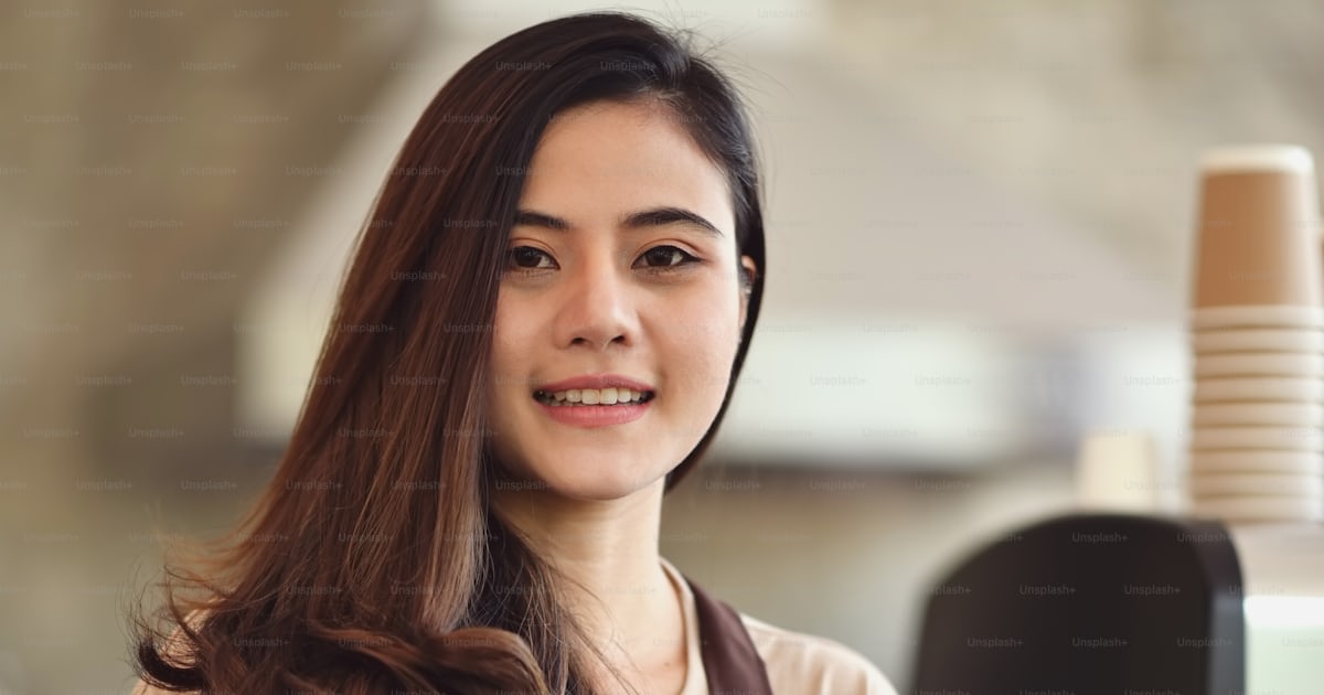 コーヒーバーのカウンターの前に立つ魅力的なアジアのバリスタ女性のポートレート。の写真 タイ Unsplashの写真