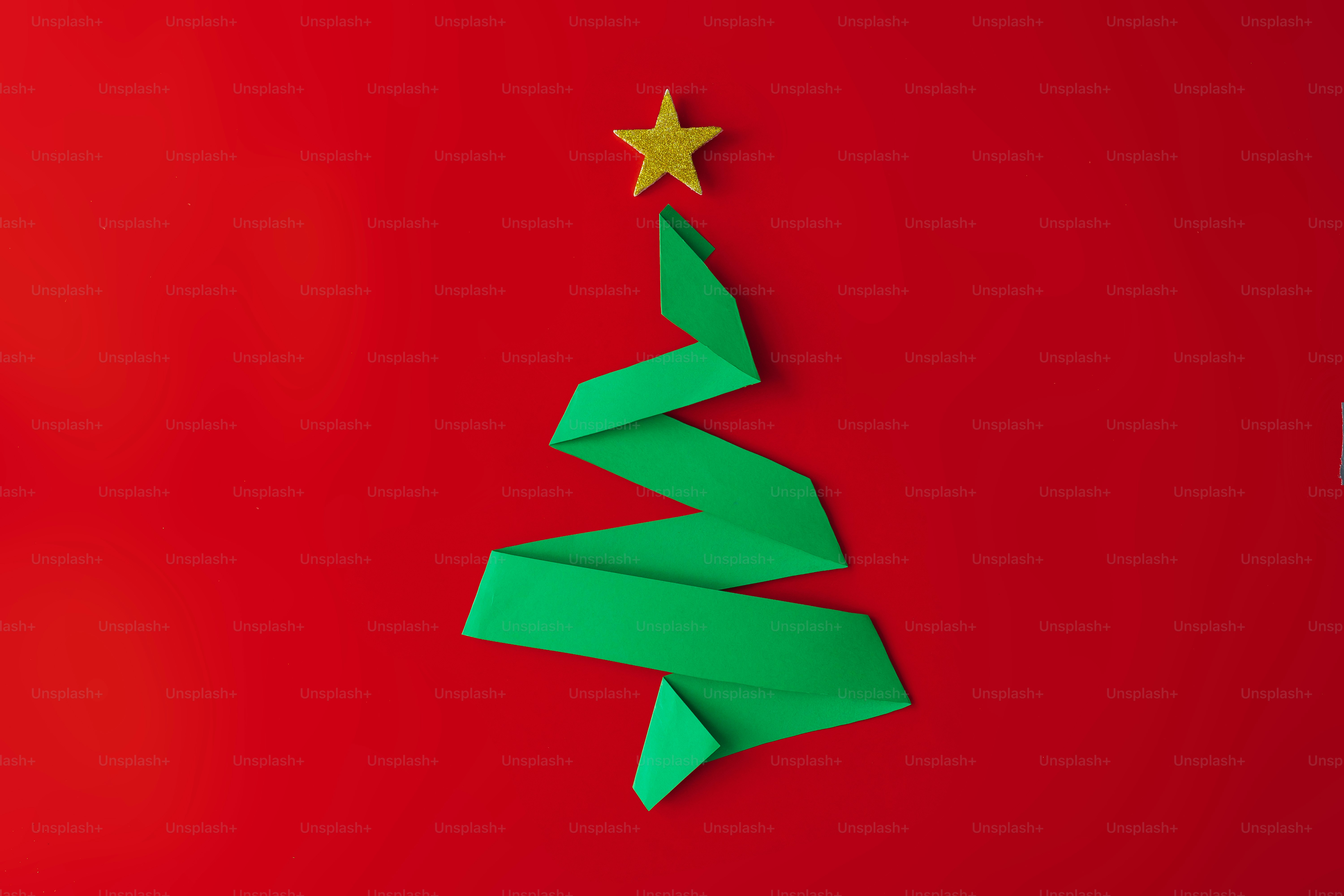 Minimal origami style folded paper christmas tree on red background ...