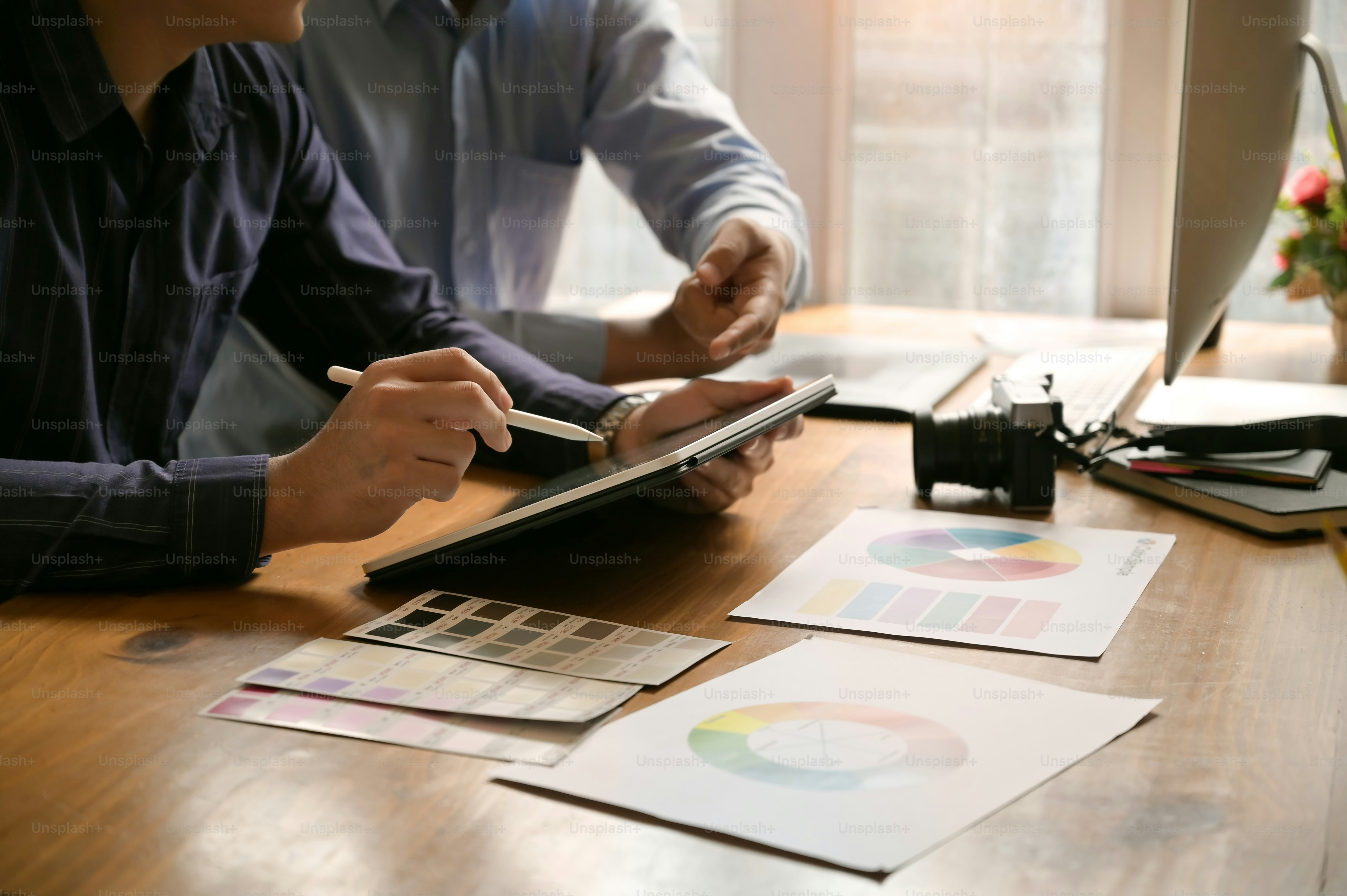 Colleagues discussing photographs at creative office, Photo editor job ...