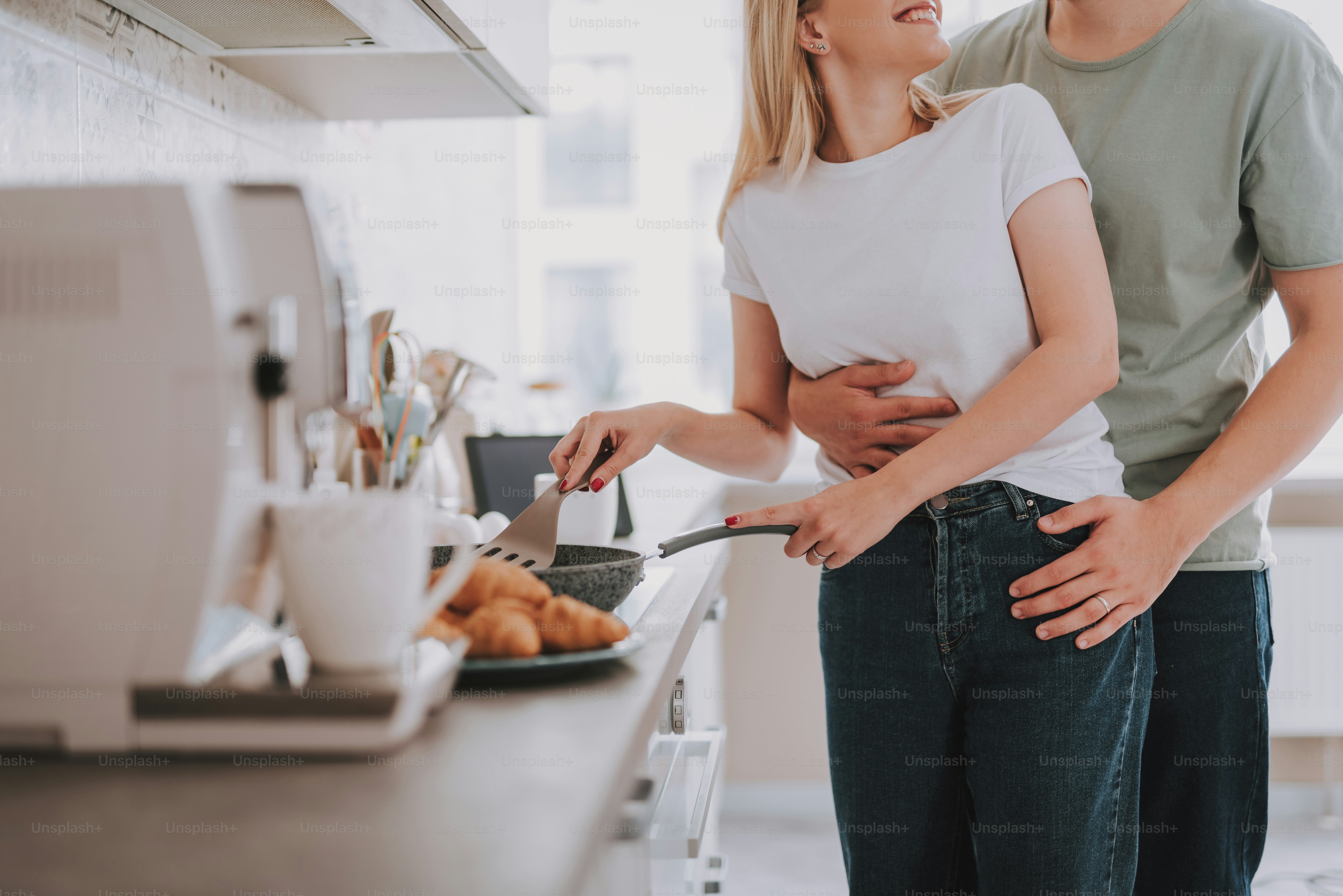 Young happy couple in morning. Woman roasting something and smiling for ...