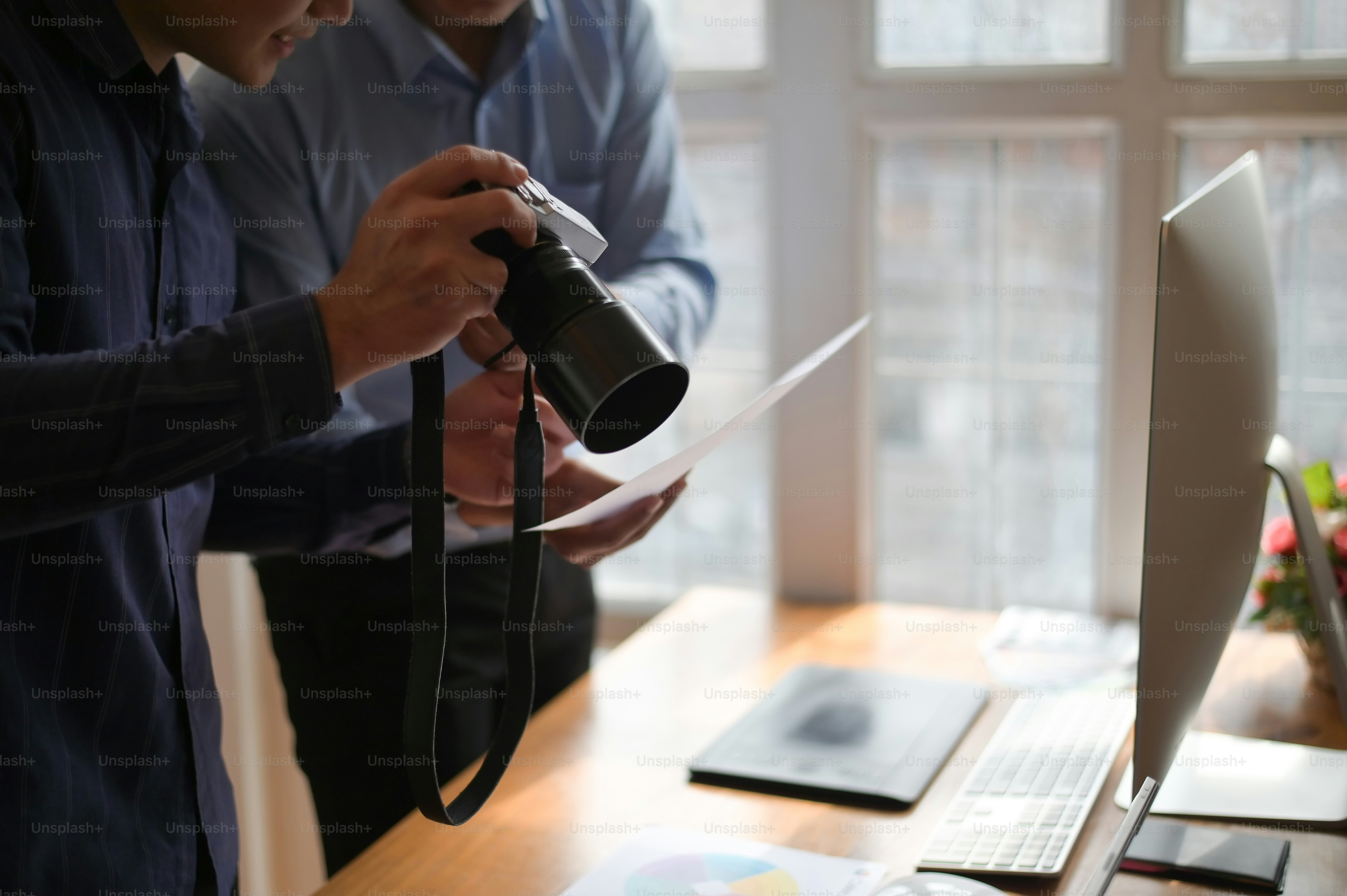 Photographer Colleagues discussing photographs at creative office ...