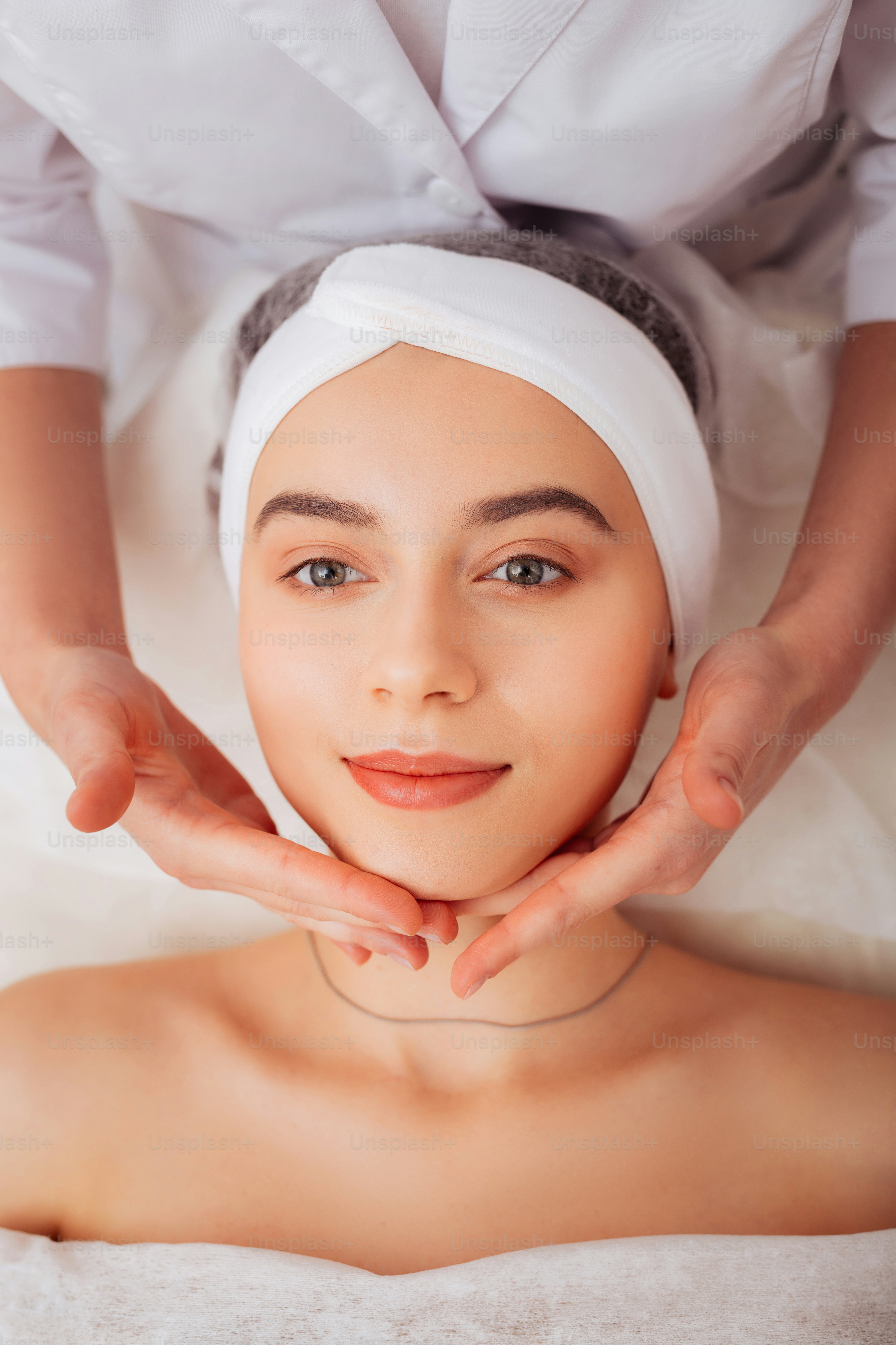 Beginning of the massage. Soft female hands touching the clients chin ...